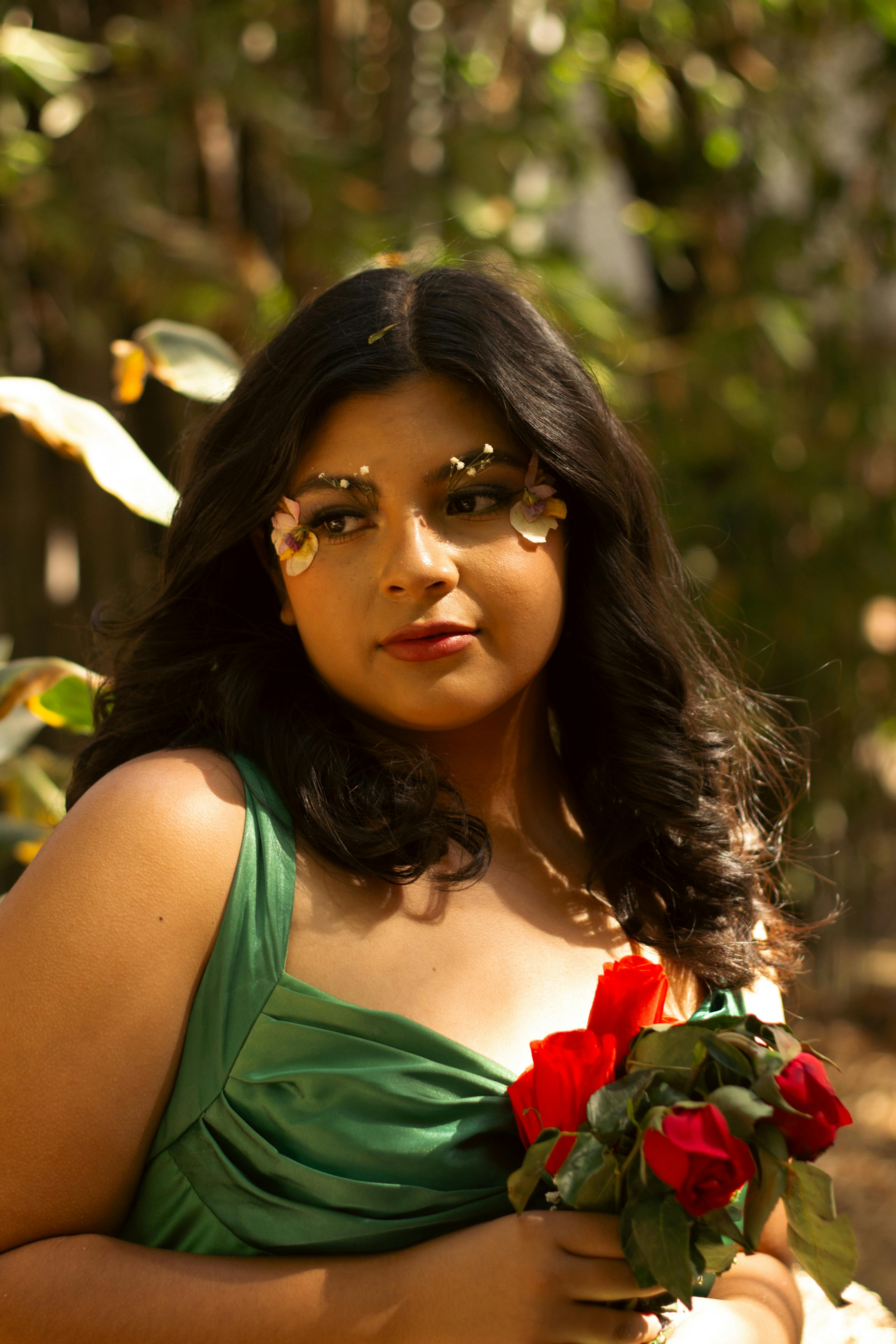 Elegant Woman Holding Roses in Nature Setting · Free Stock Photo