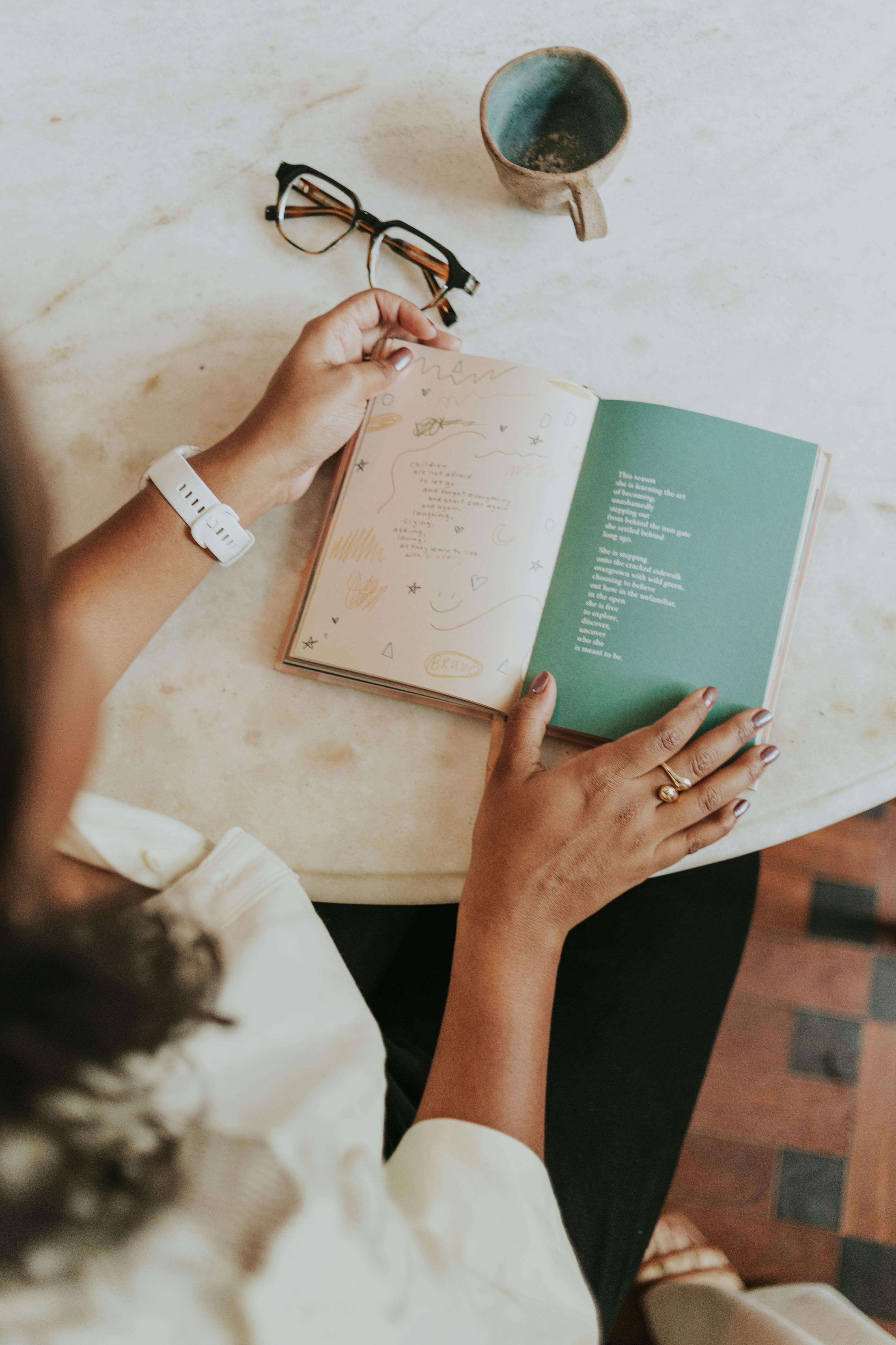 Woman Reading Poetry at Marble Table in Morning Light · Free Stock Photo