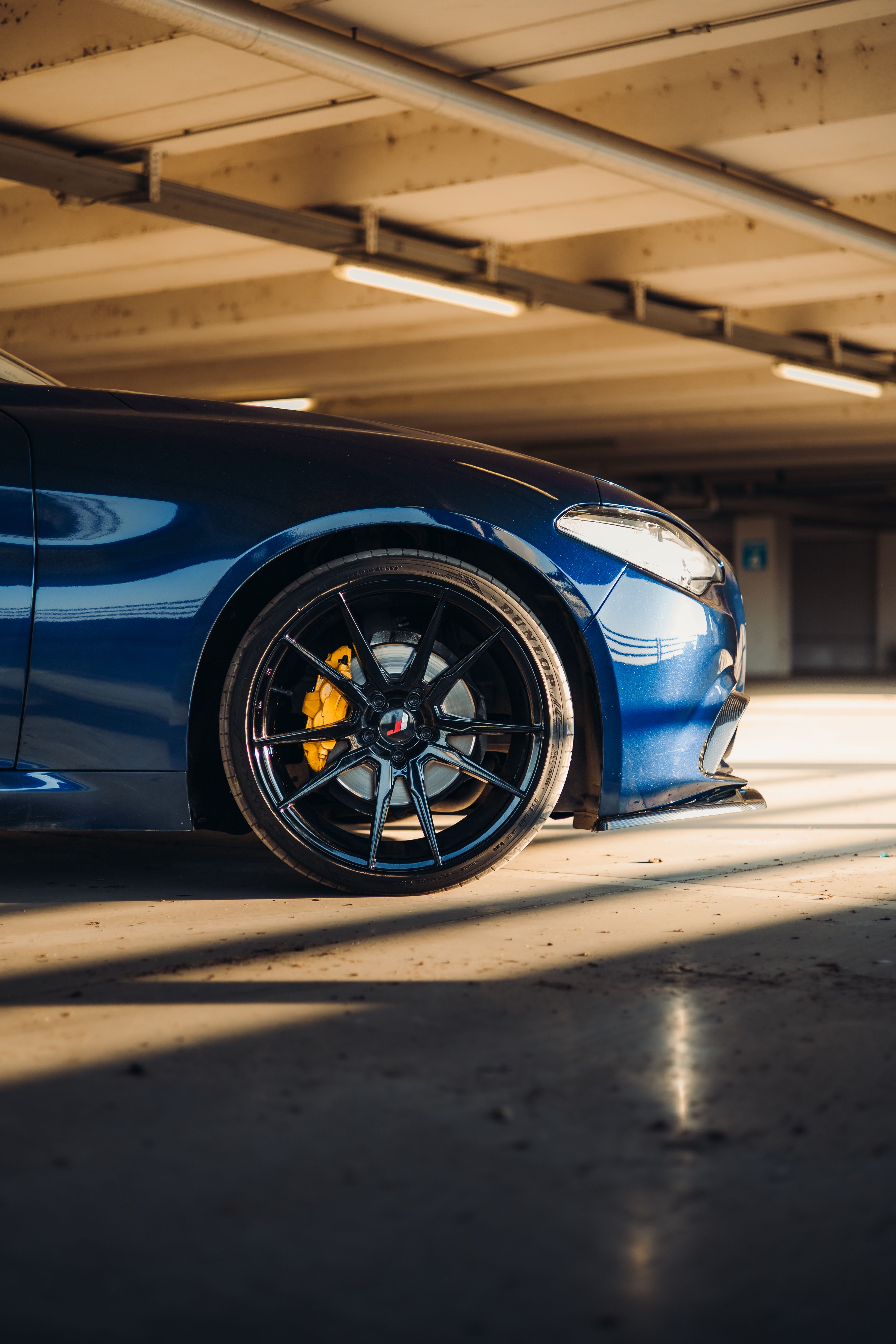 Luxury Blue Car in Sunlit Parking Garage · Free Stock Photo