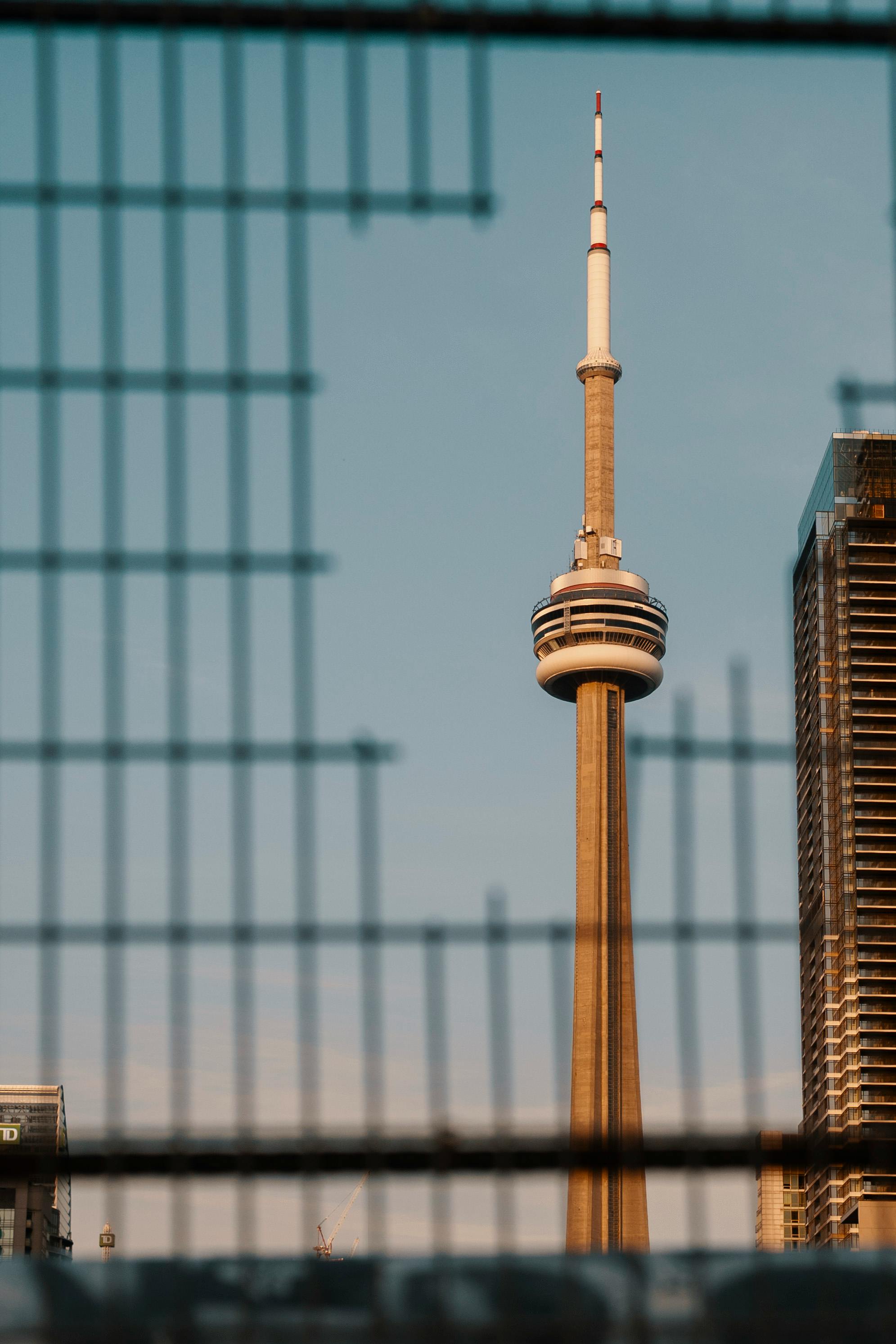 Pemandangan Menara Cn Yang Ikonik Melalui Pagar Logam · Foto Stok Gratis