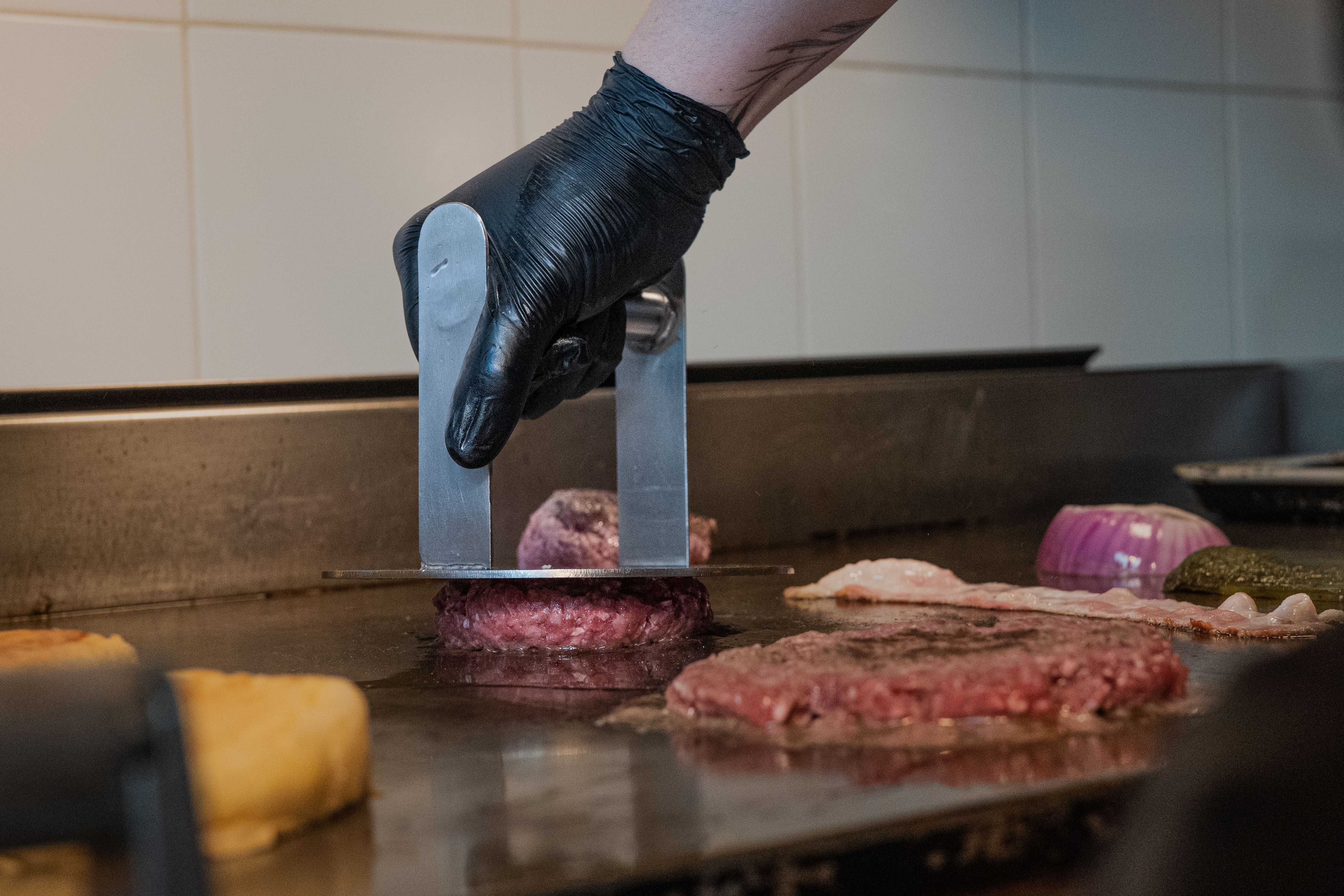 Chef Preparing Gourmet Burger on Grill · Free Stock Photo