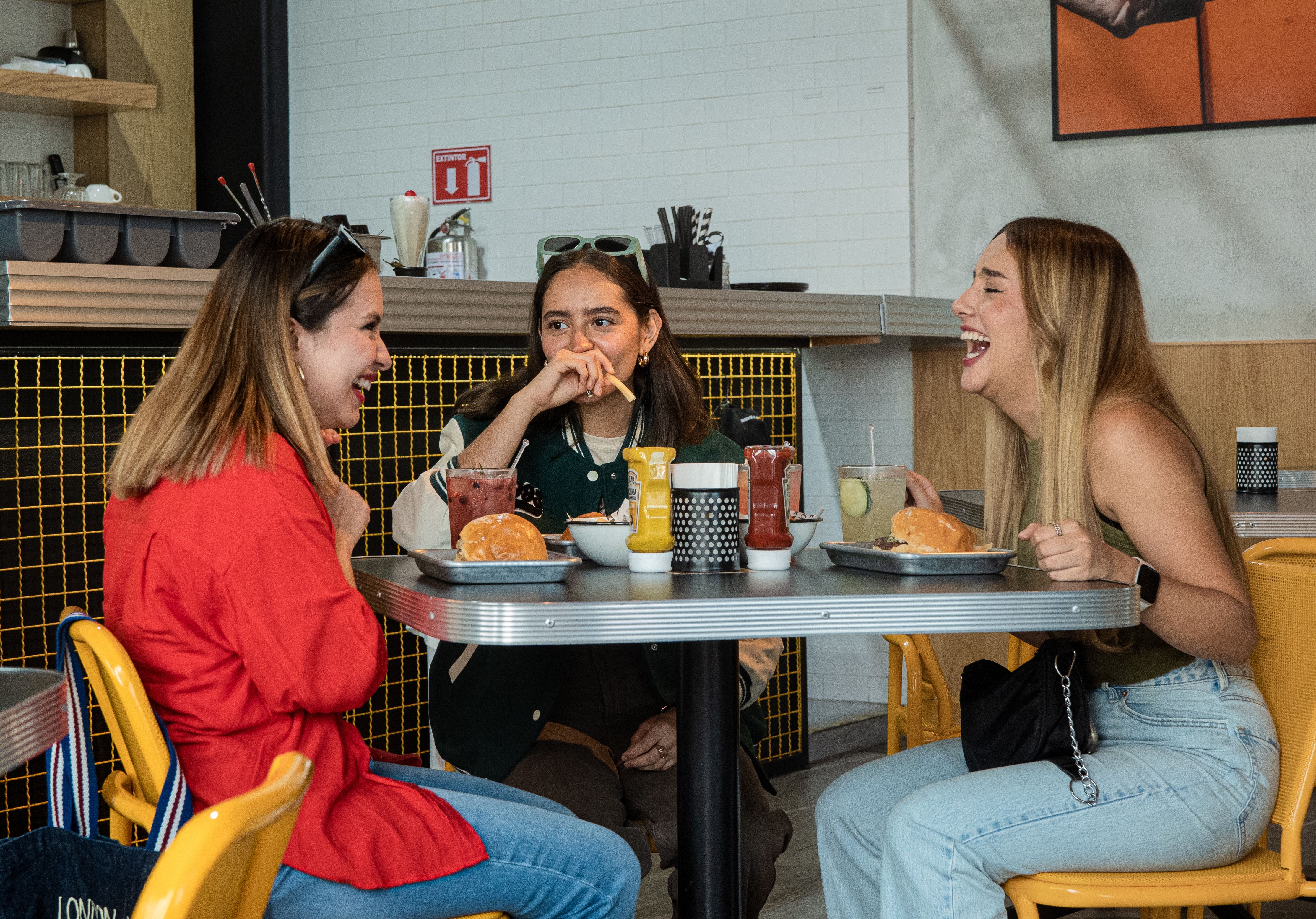 Friends Enjoying Burgers at a Cafe · Free Stock Photo