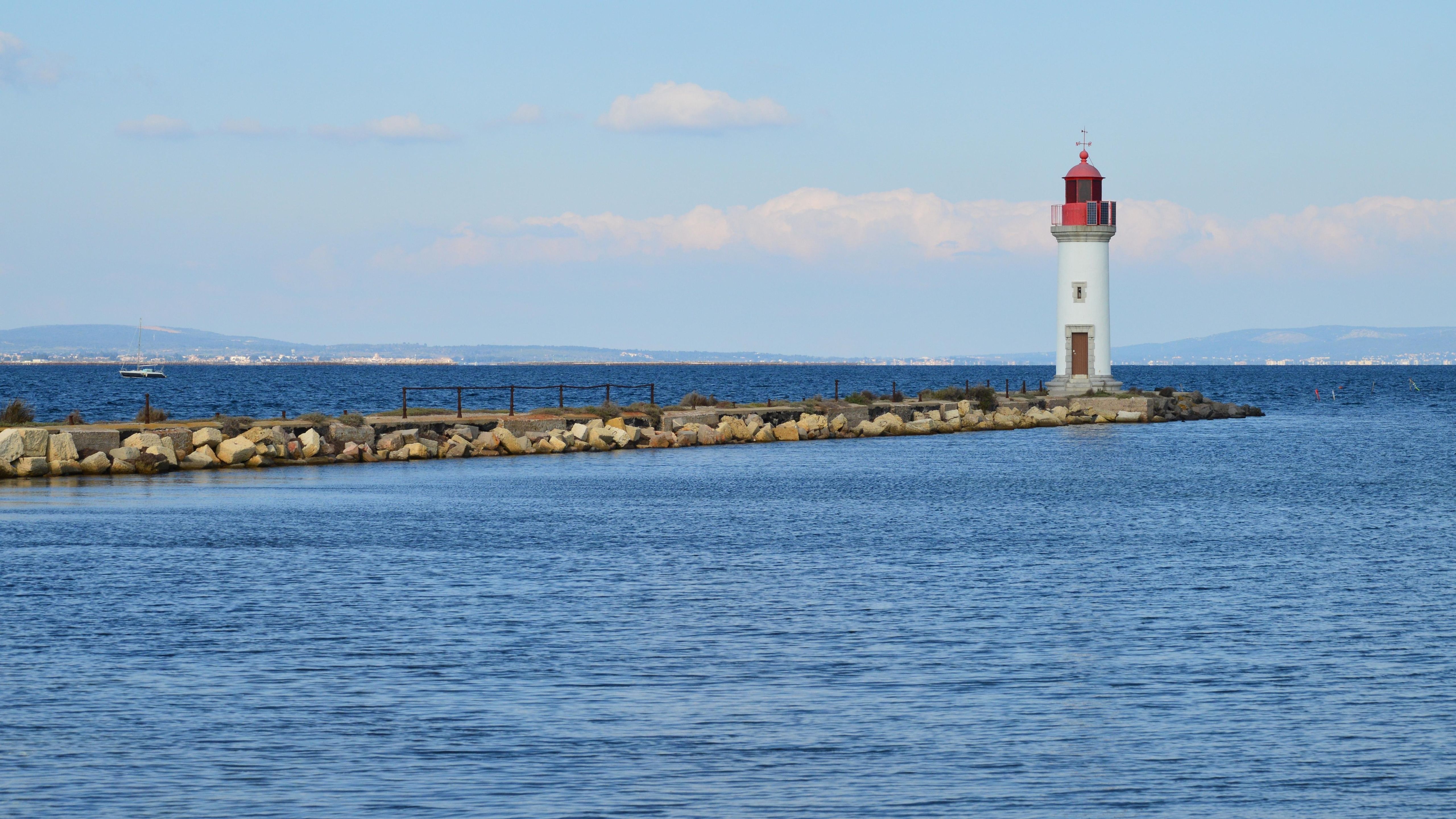 Scenic Lighthouse and Jetty by Tranquil Sea · Free Stock Photo