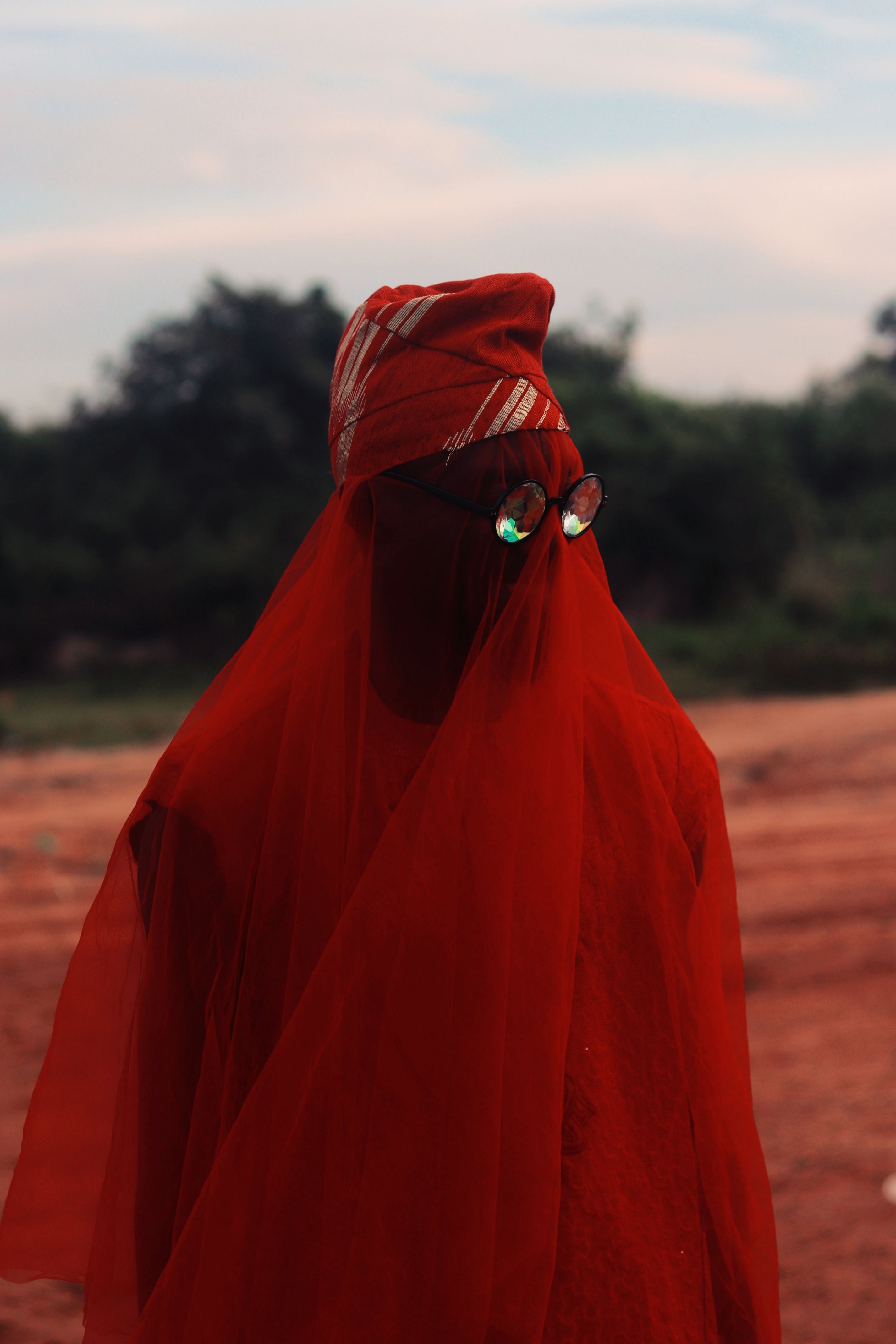 Mysterious Figure in Red Veil Outdoors · Free Stock Photo