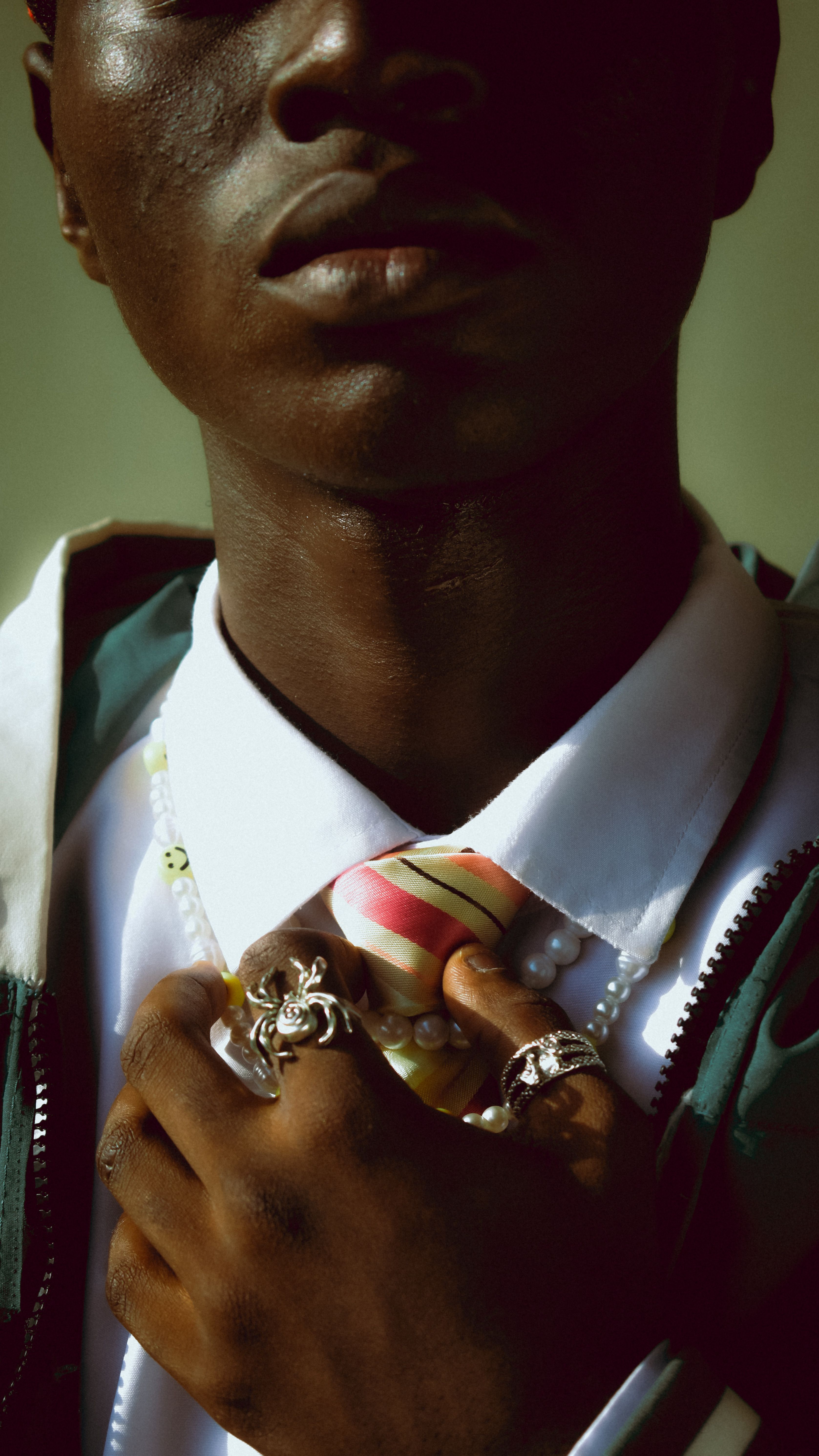 Stylish Man Adjusting Colorful Necktie with Rings · Free Stock Photo