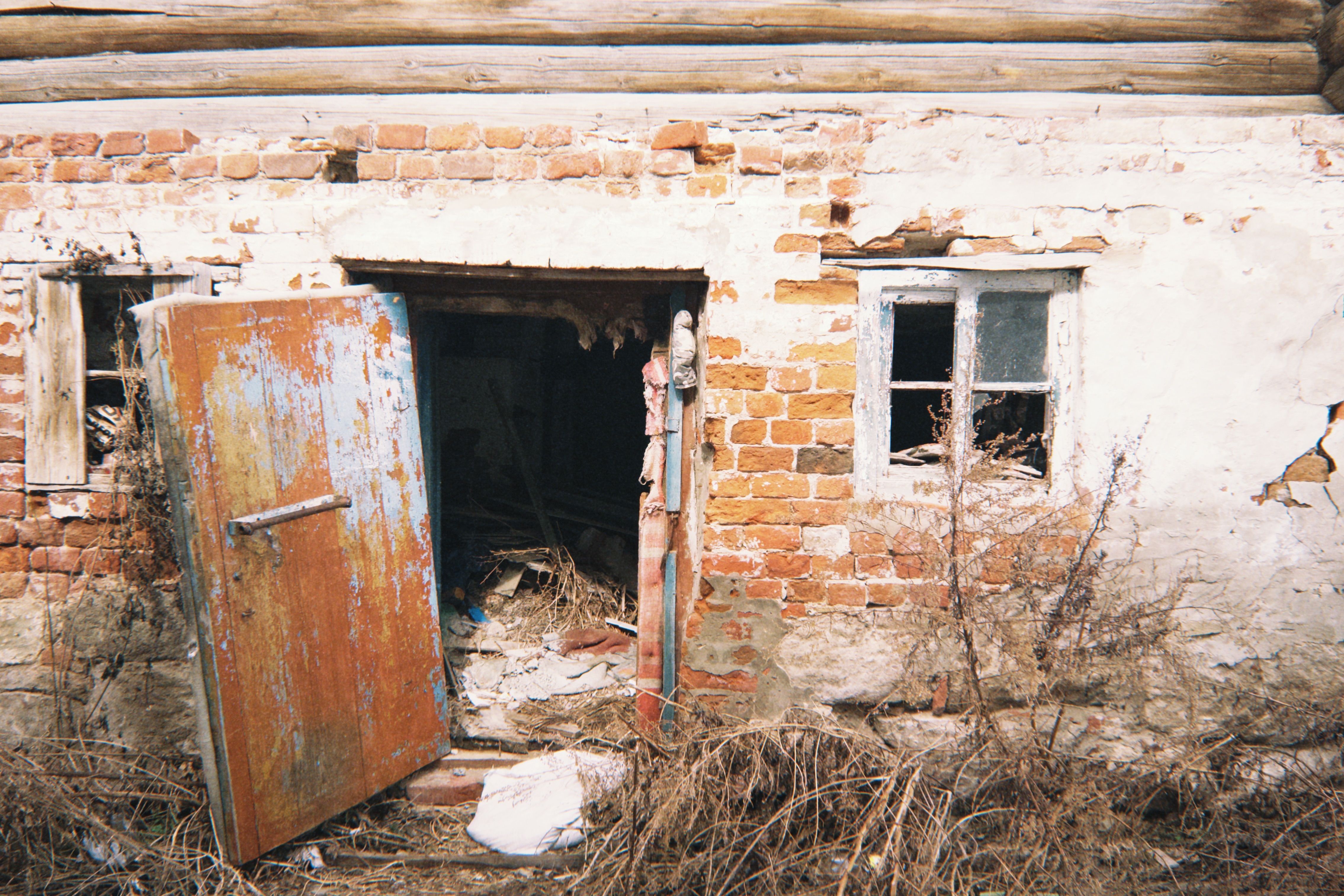 Weathered Abandoned Brick House with Open Door · Free Stock Photo