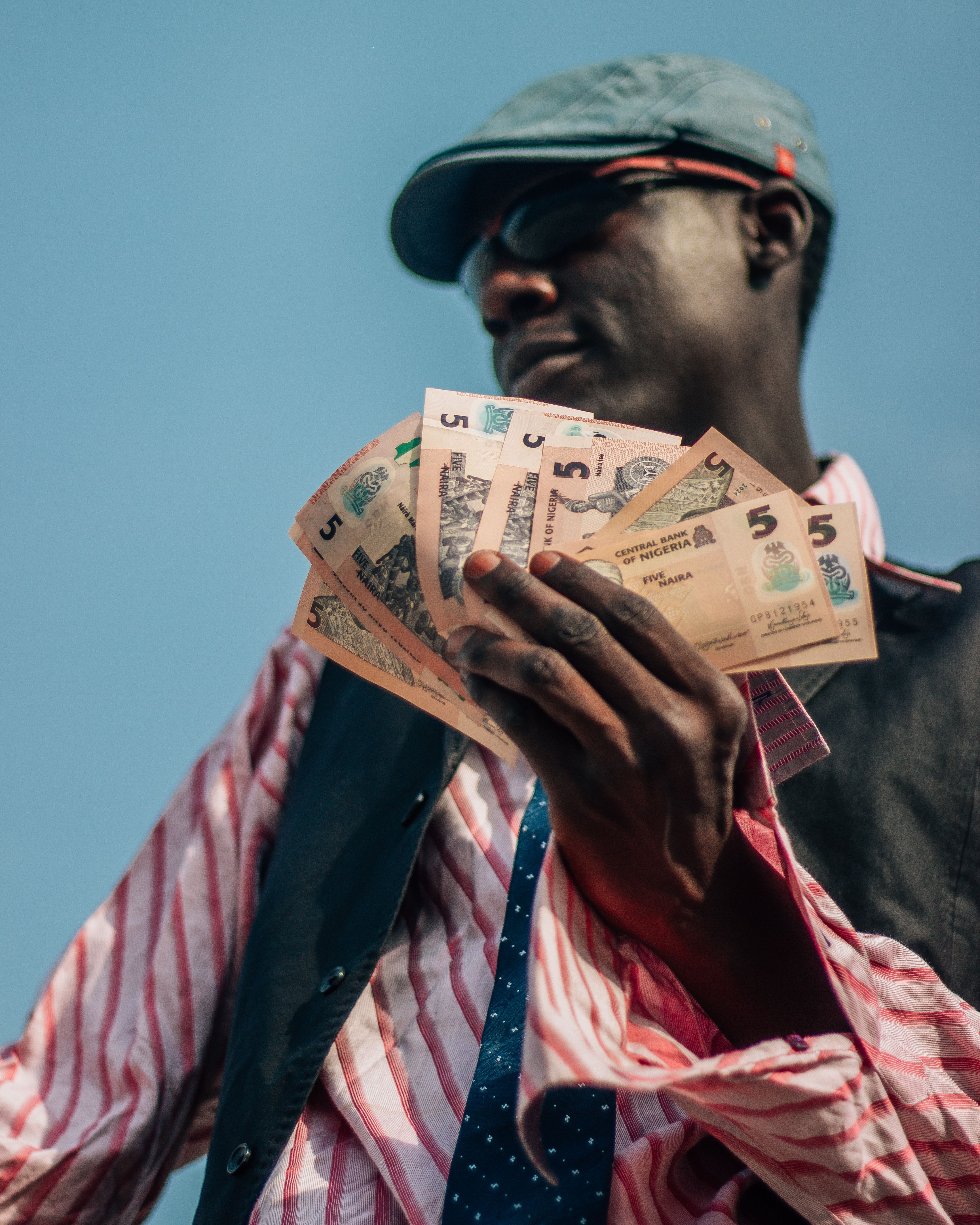 Man Holding Currency Notes Outdoors · Free Stock Photo