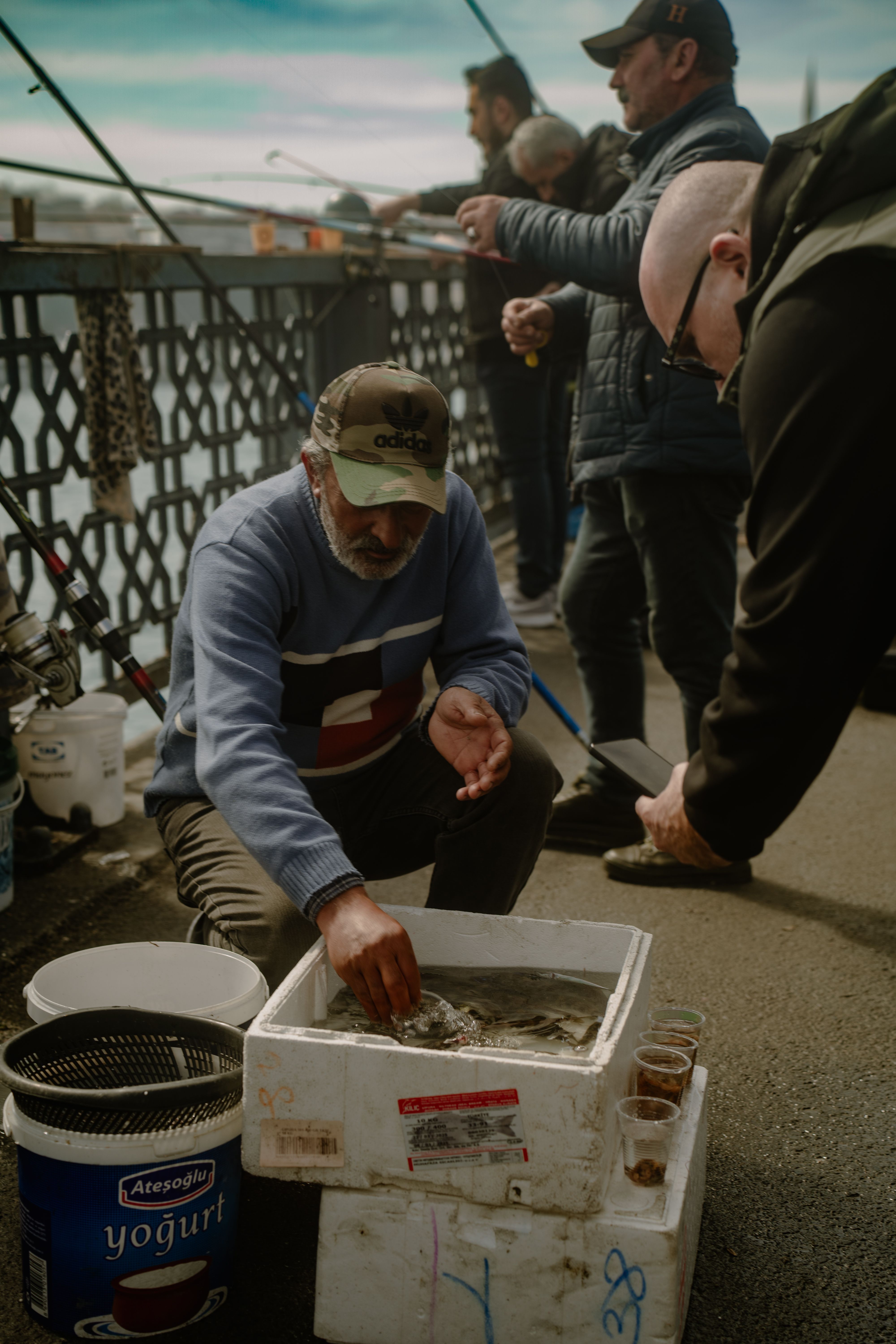 Fishing Scene on Bridge with Fishermen and Equipment · Free Stock Photo