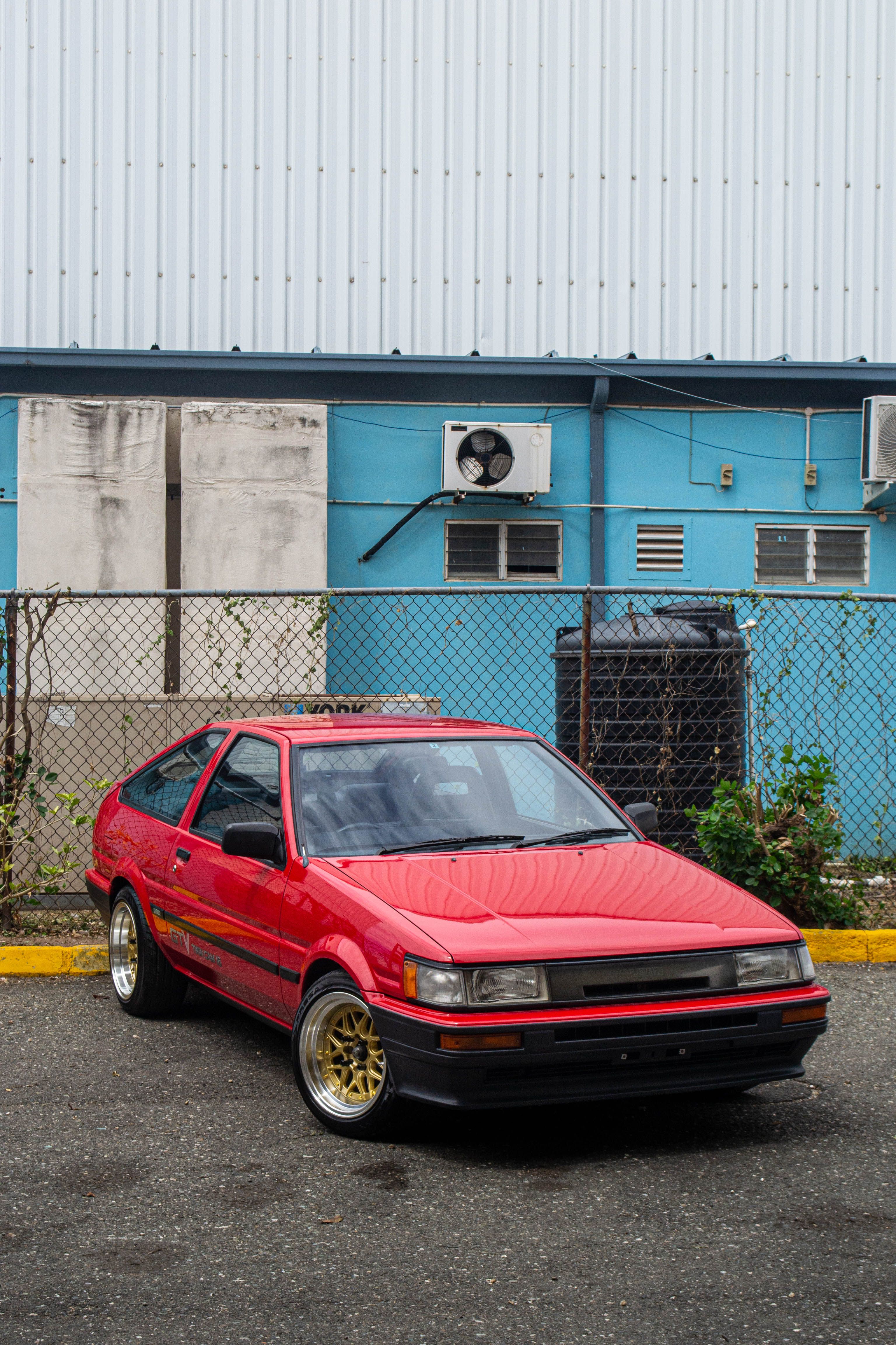 Classic Red Car in Urban Industrial Setting · Free Stock Photo