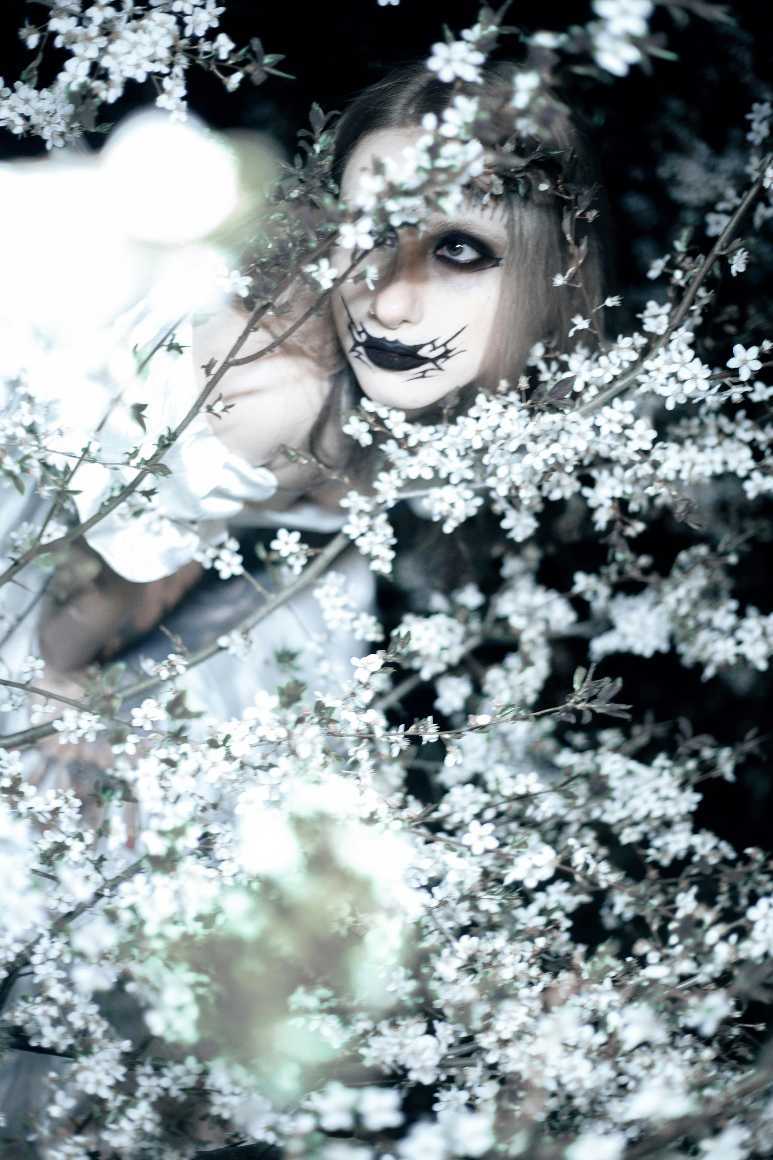 Ethereal Gothic Woman Behind Blossoming Branches · Free Stock Photo
