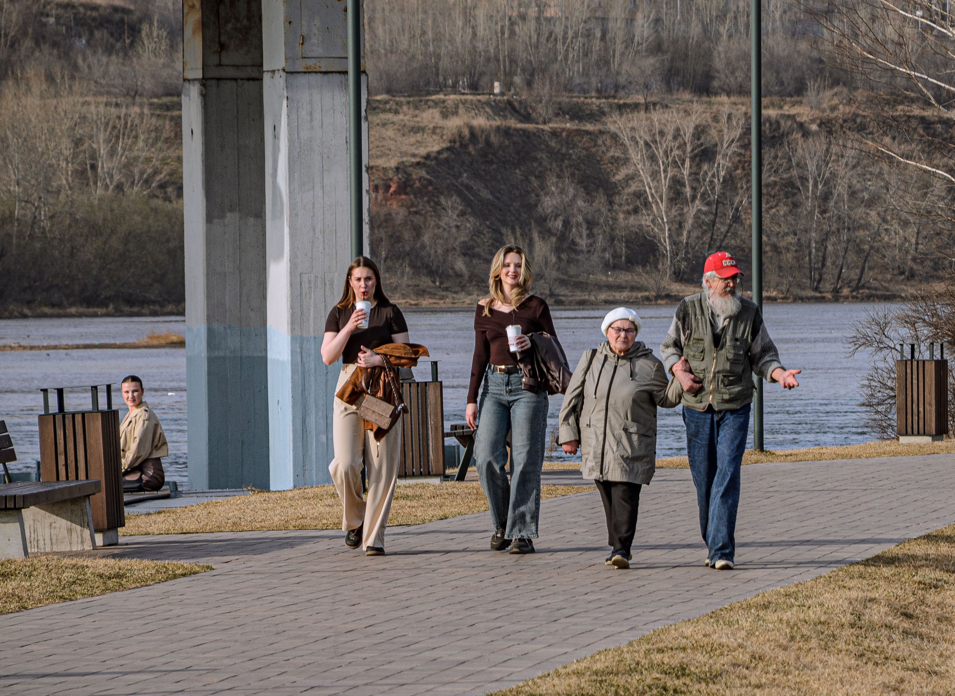 Group Walking Along Riverside Path in Spring · Free Stock Photo