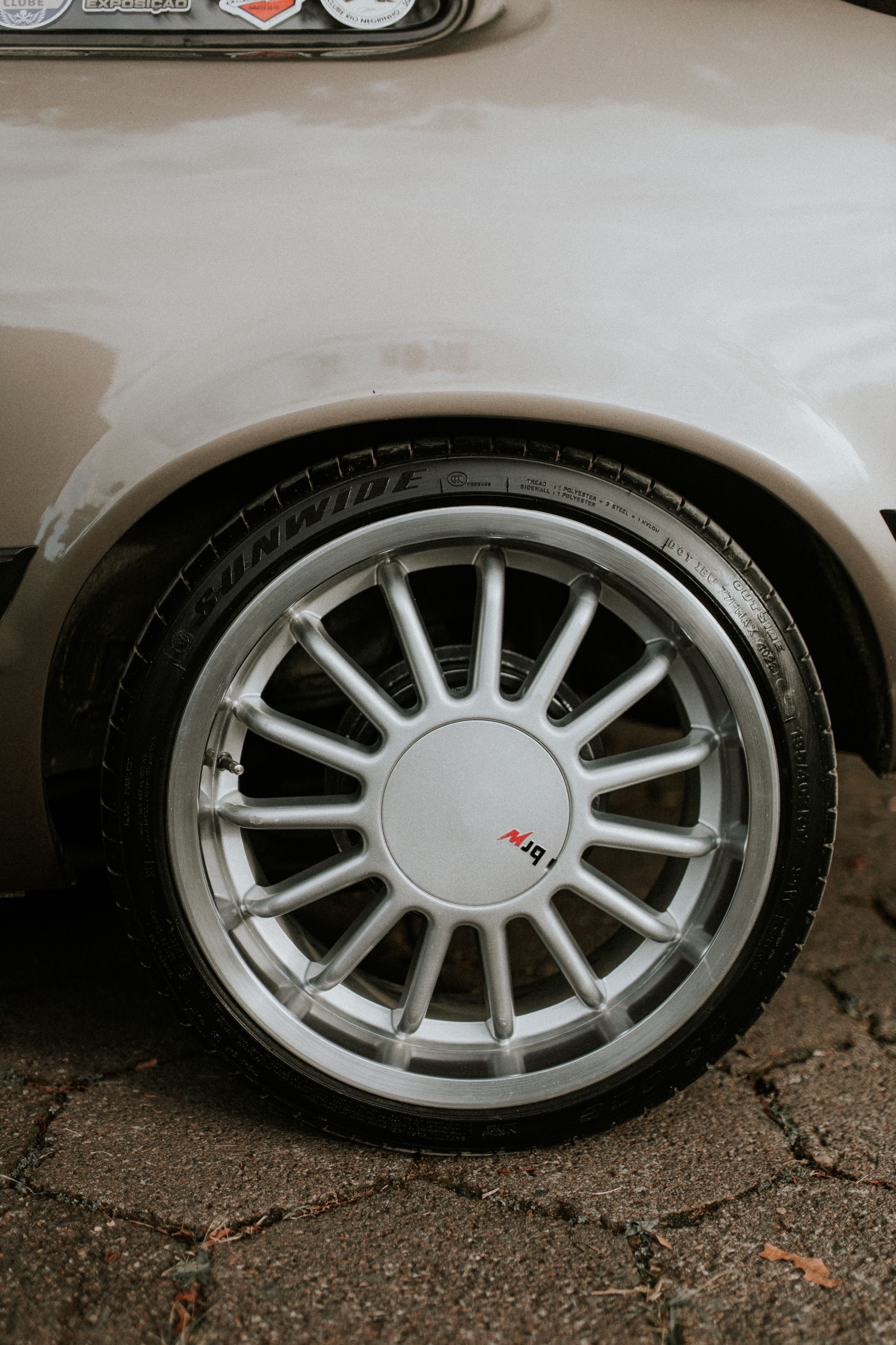 Close-Up of Stylish Modern Car Wheel on Pavement · Free Stock Photo