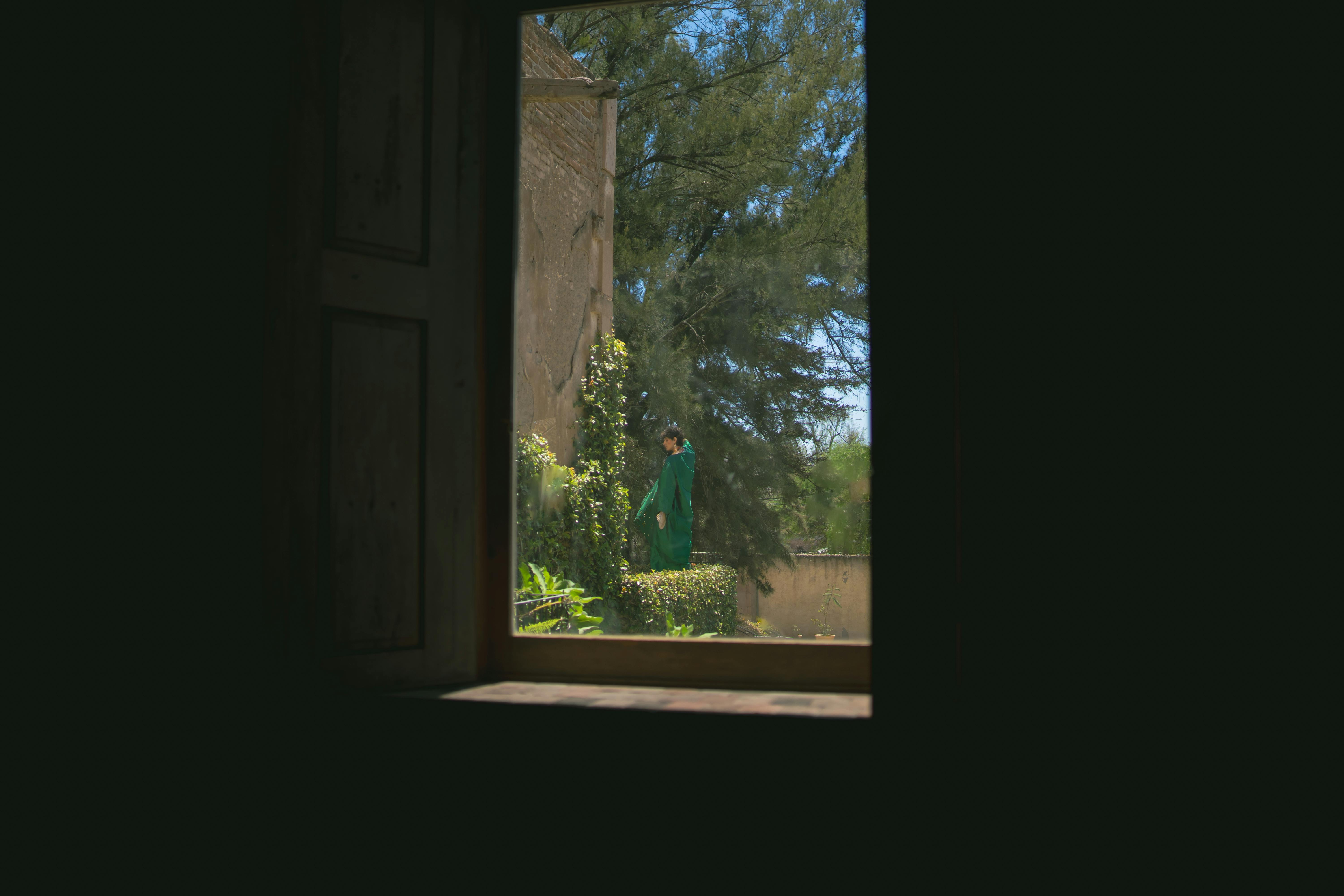 Serene Outdoor Portrait through a Window Frame · Free Stock Photo