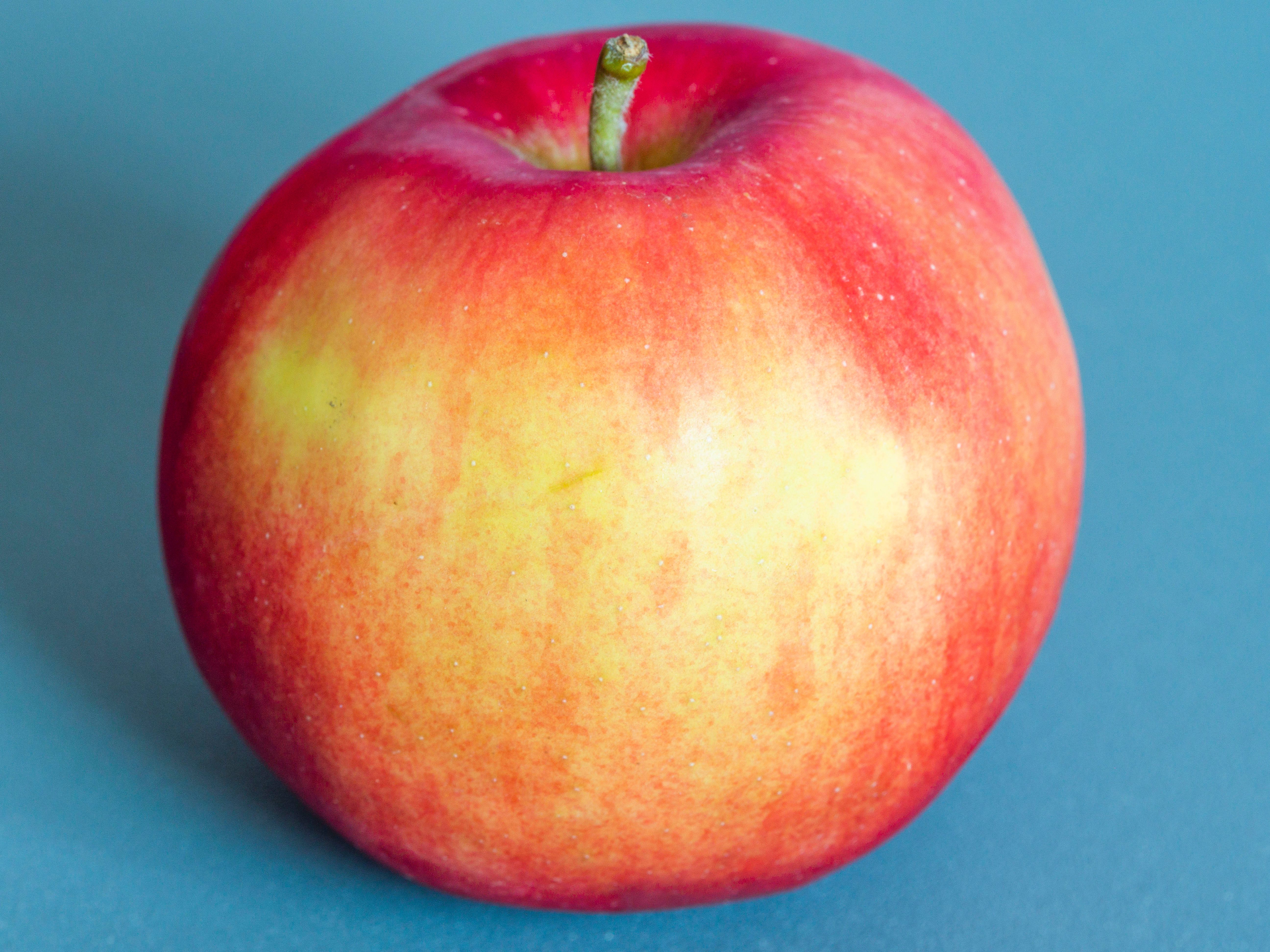 Close-up of Fresh Red Apple on Blue Background · Free Stock Photo