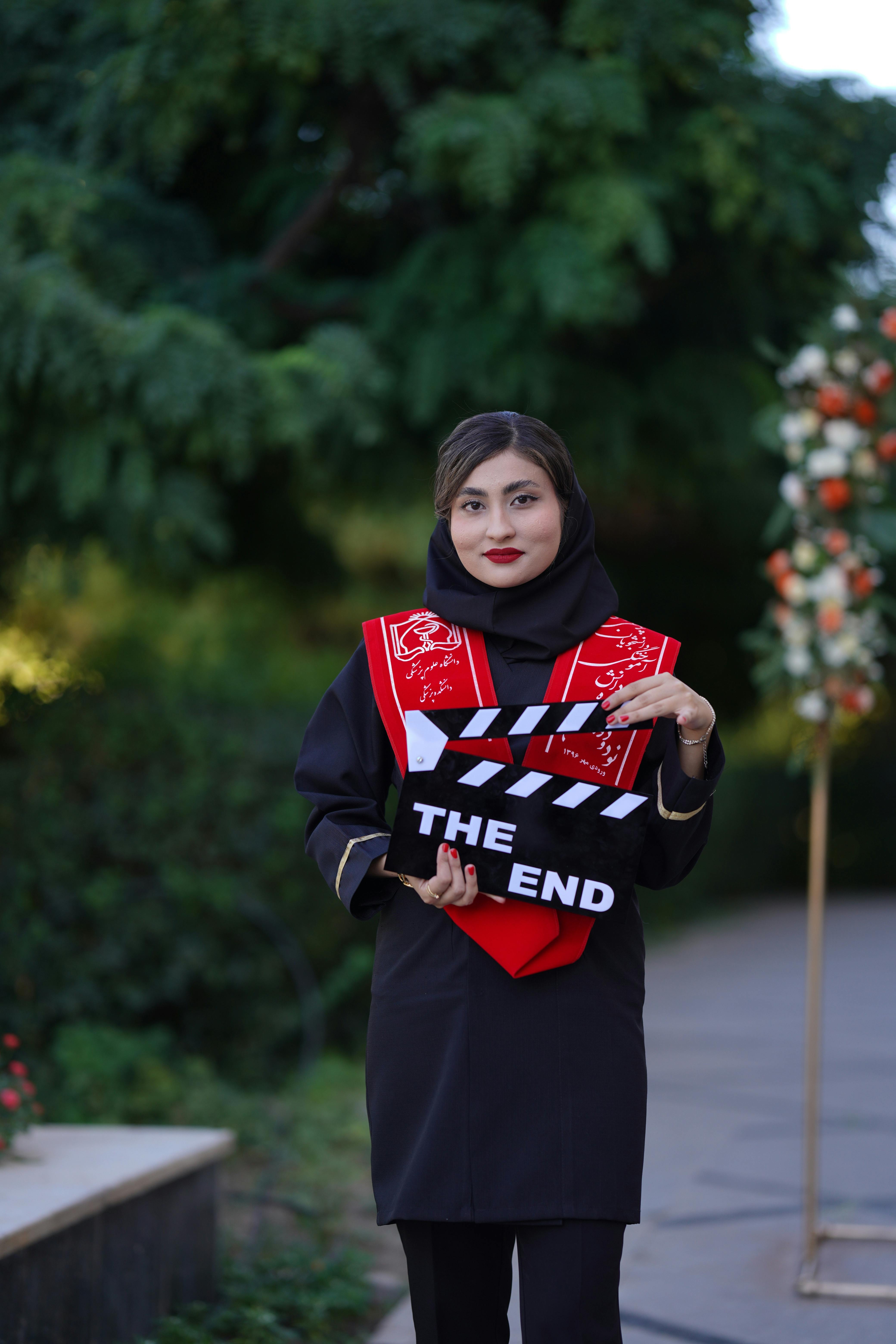 Elegant Graduation Portrait with Clapperboard · Free Stock Photo