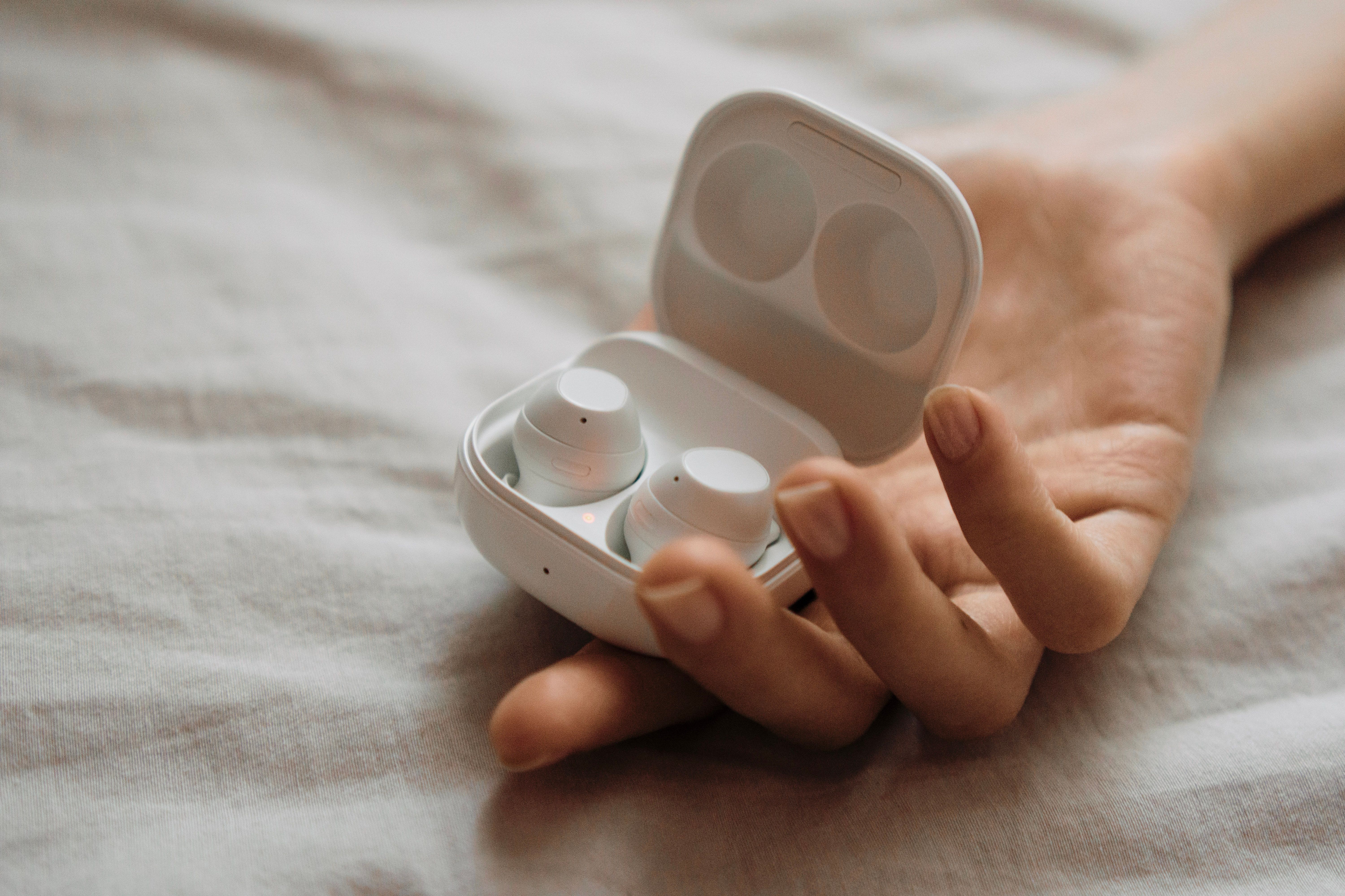 Close-up of White Wireless Earbuds in Hand · Free Stock Photo