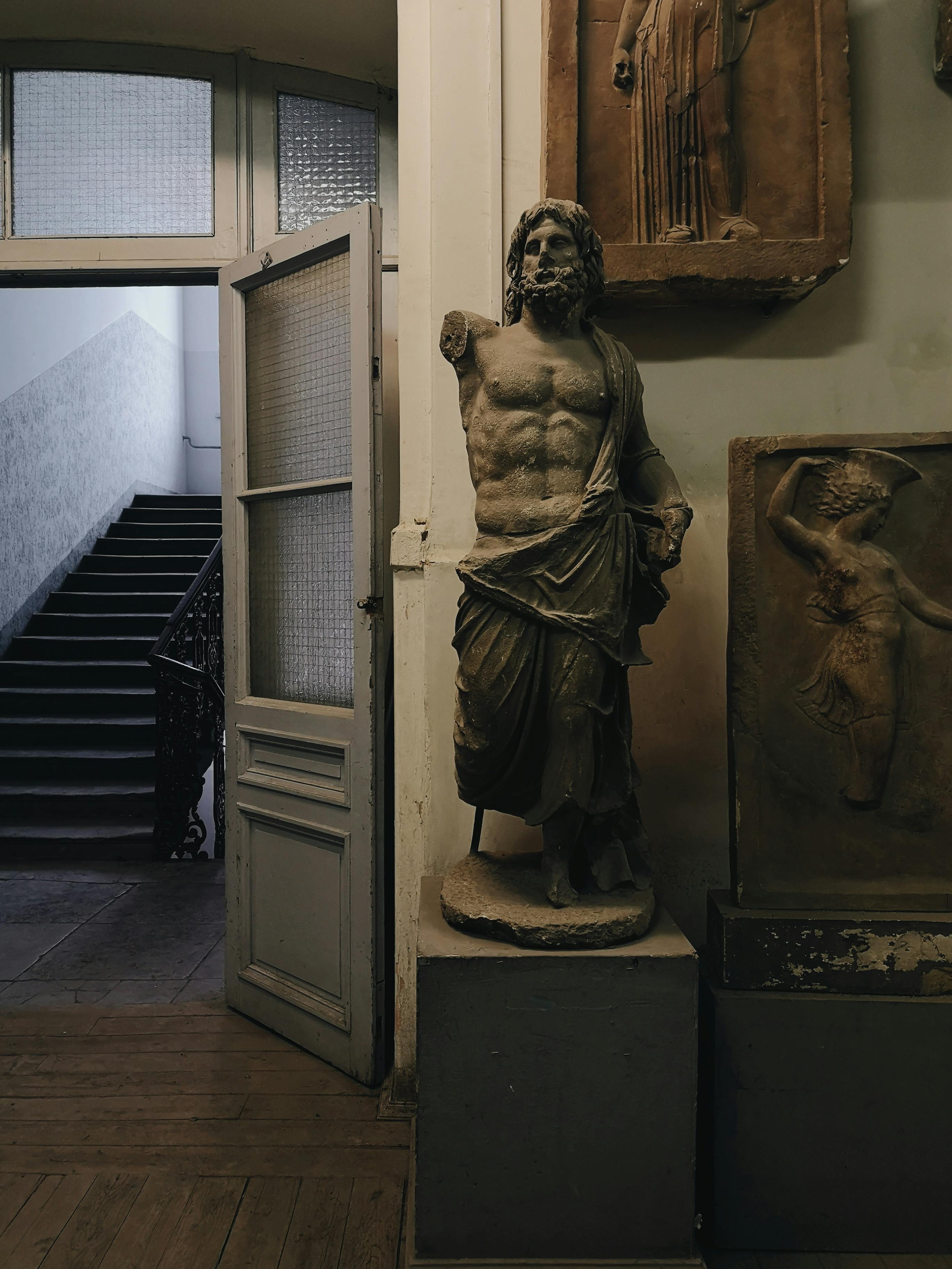 Man Statue Beside Embossed Portraits · Free Stock Photo