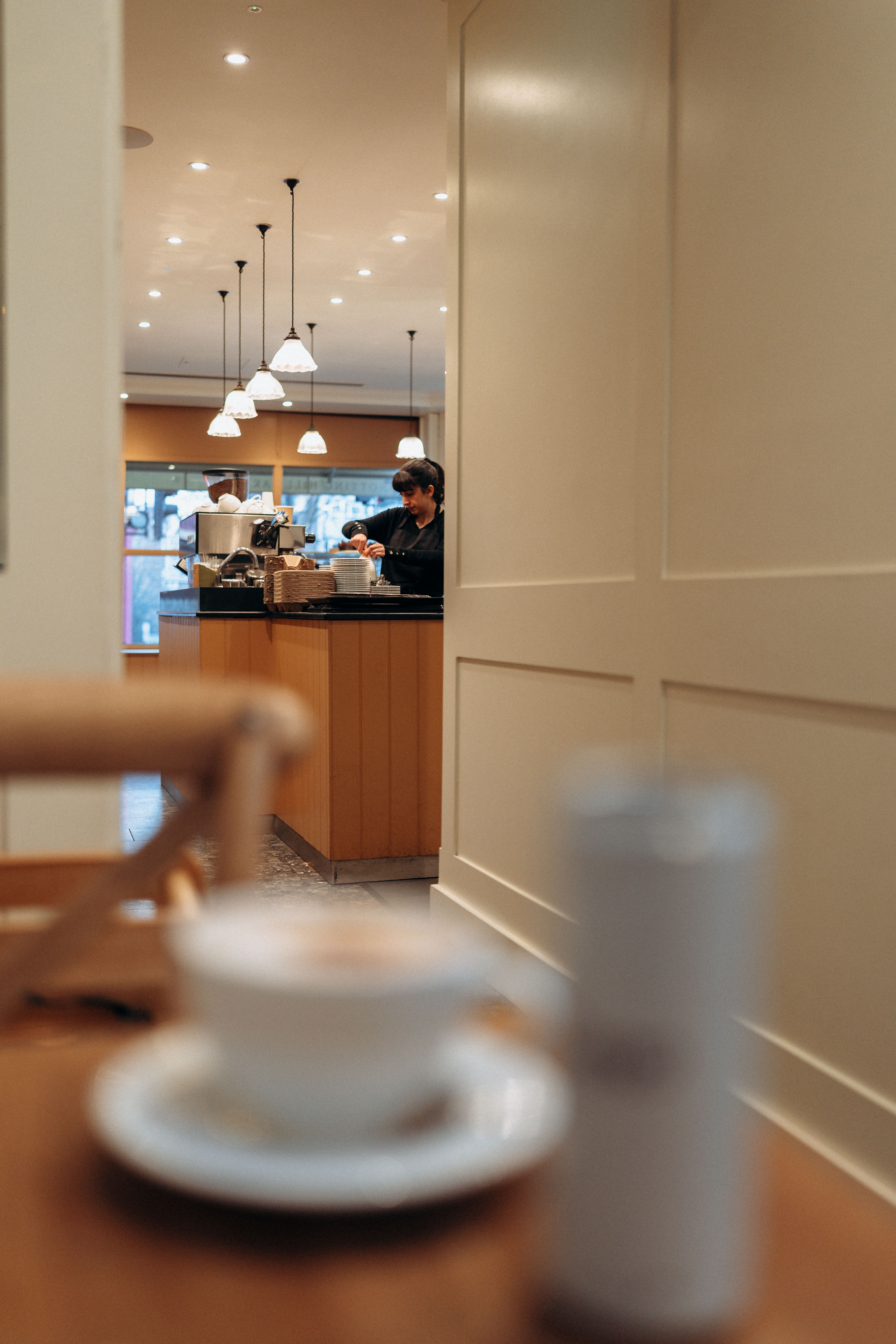 Cozy Coffee Shop Interior with Barista at Work · Free Stock Photo
