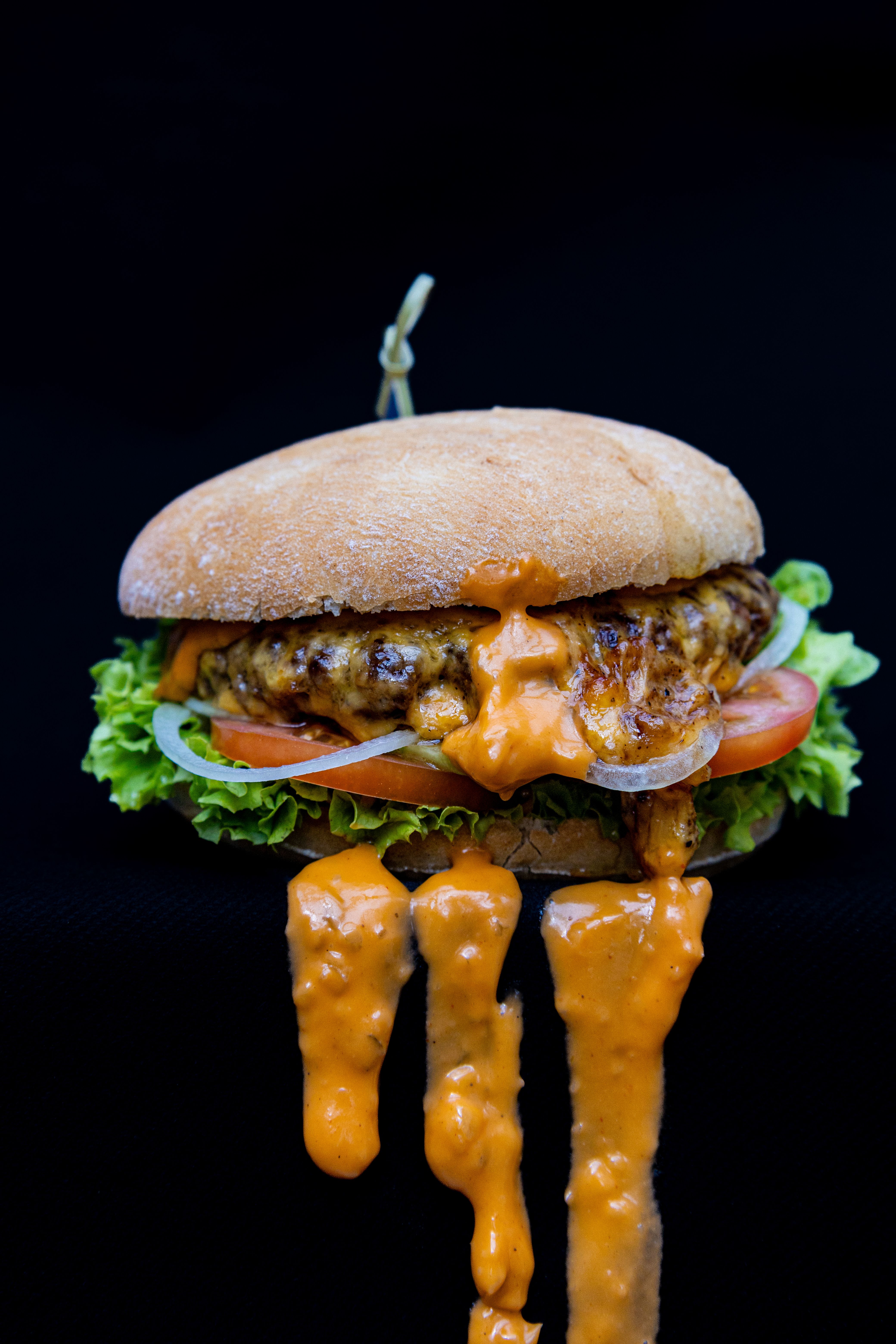 Delicious Gourmet Burger with Dripping Sauce · Free Stock Photo