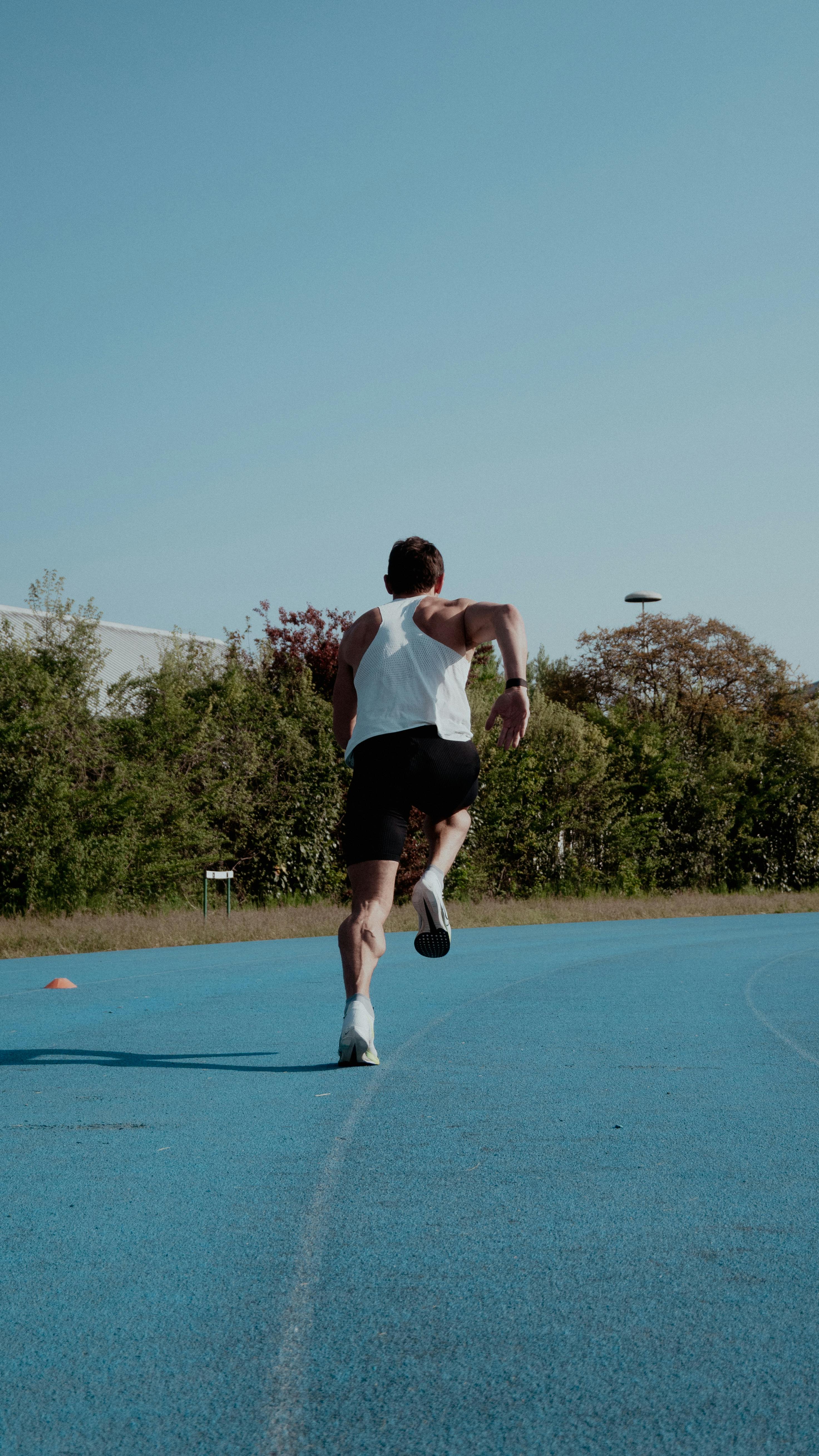 Back View of Male Athlete Sprinting on Track · Free Stock Photo