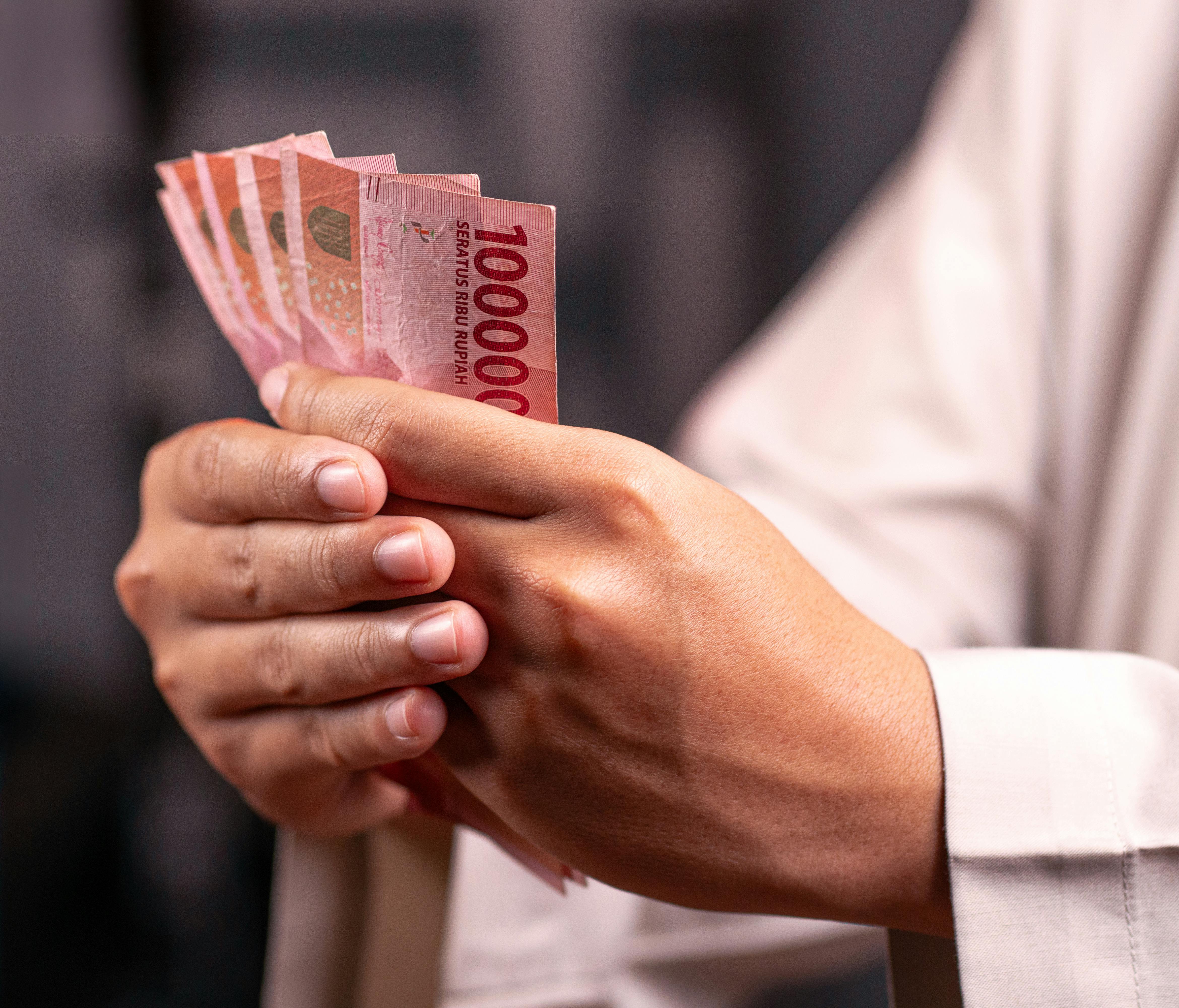 Indonesian Rupiah Hand Close-Up with 100,000 IDR · Free Stock Photo
