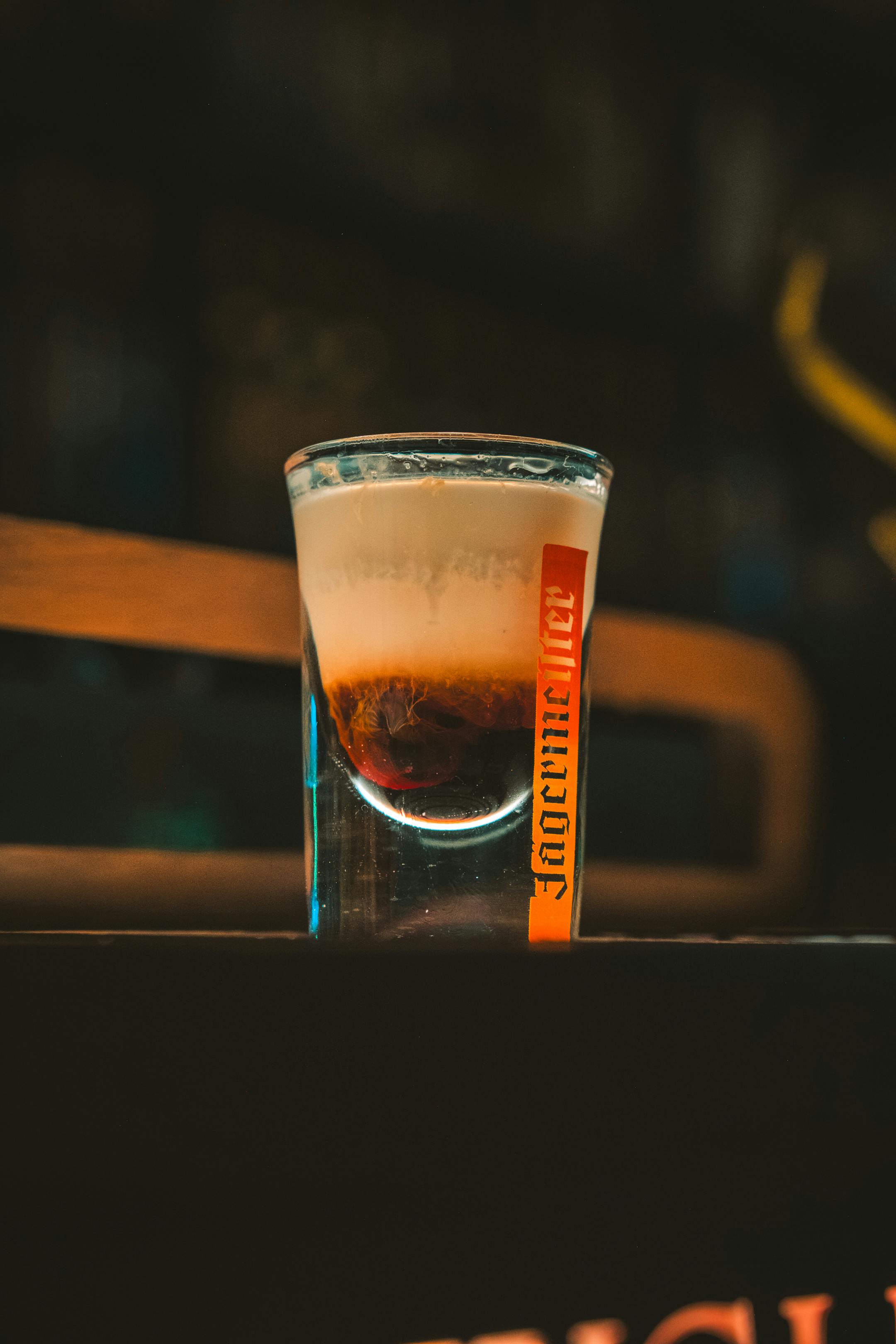Shot Glass with Layered Cocktail in a Bar Setting · Free Stock Photo