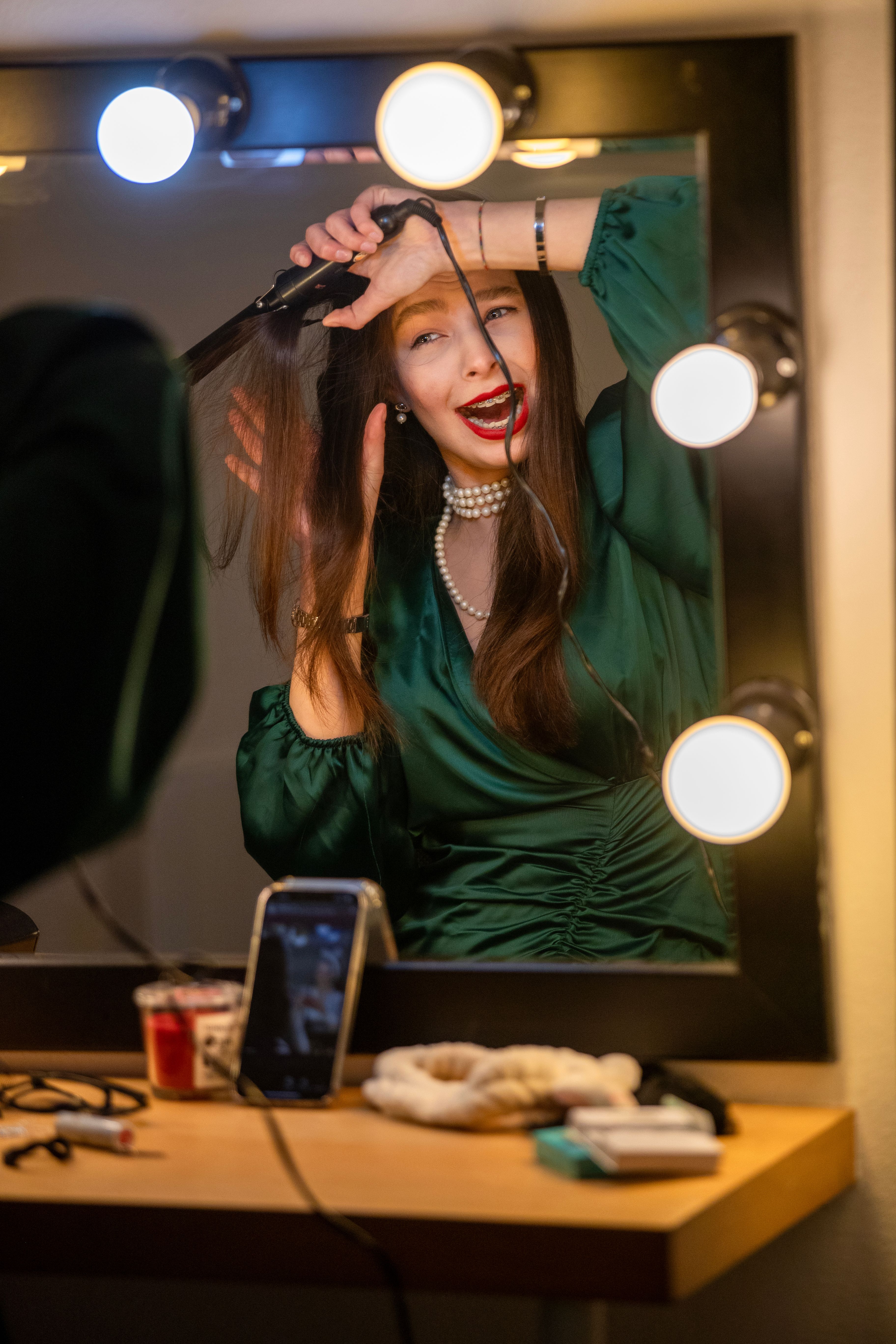 Woman Styling Hair in Dressing Room Mirror · Free Stock Photo