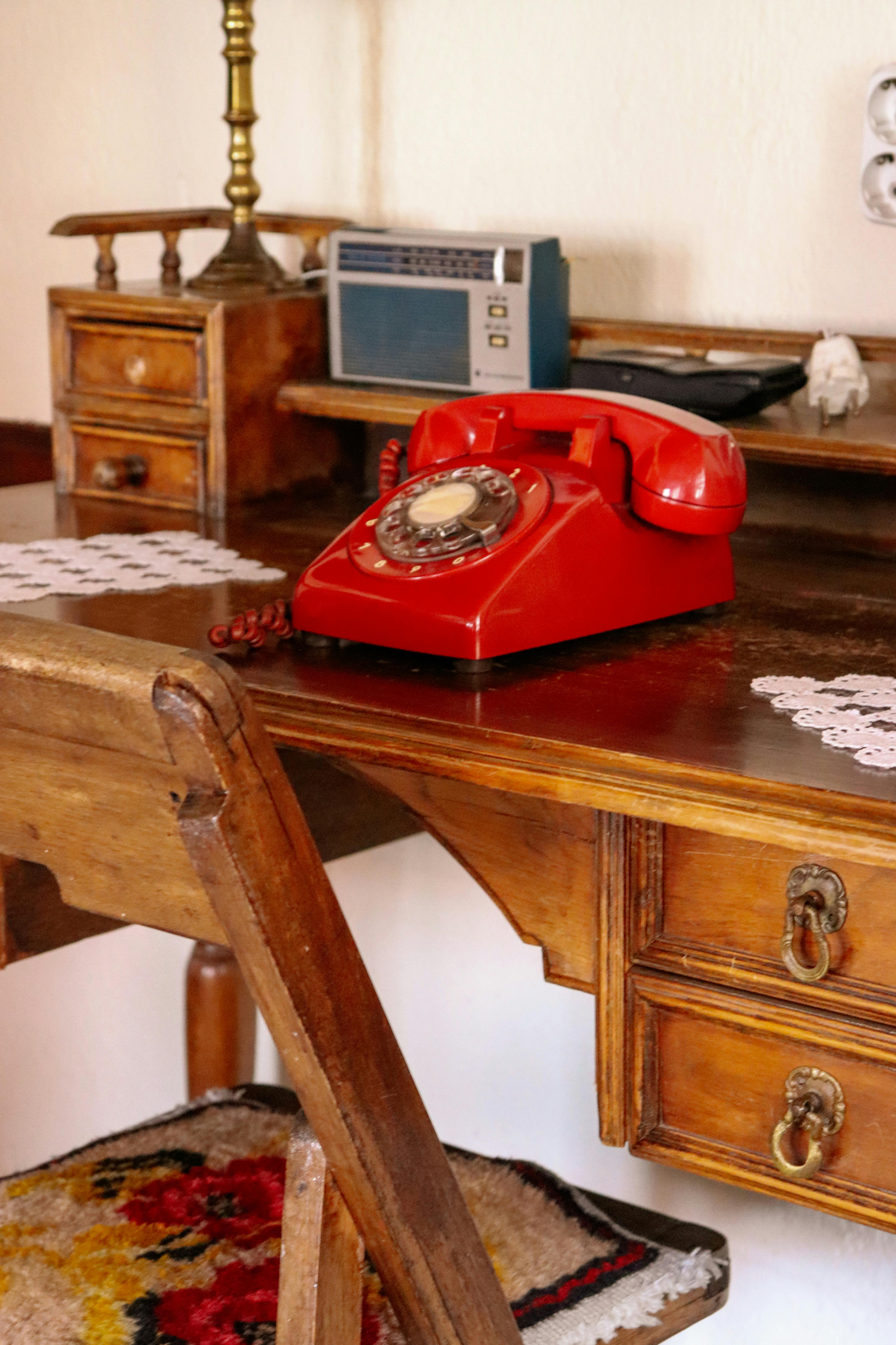 Vintage Red Rotary Phone on Rustic Desk · Free Stock Photo