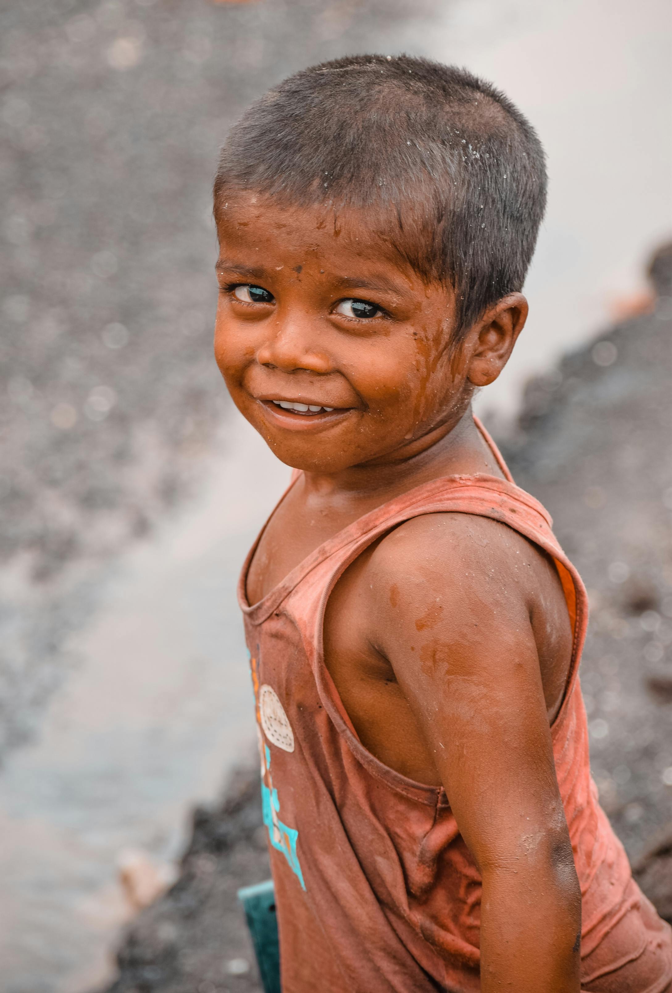 Joyful Child Playing with Tire Outdoors · Free Stock Photo
