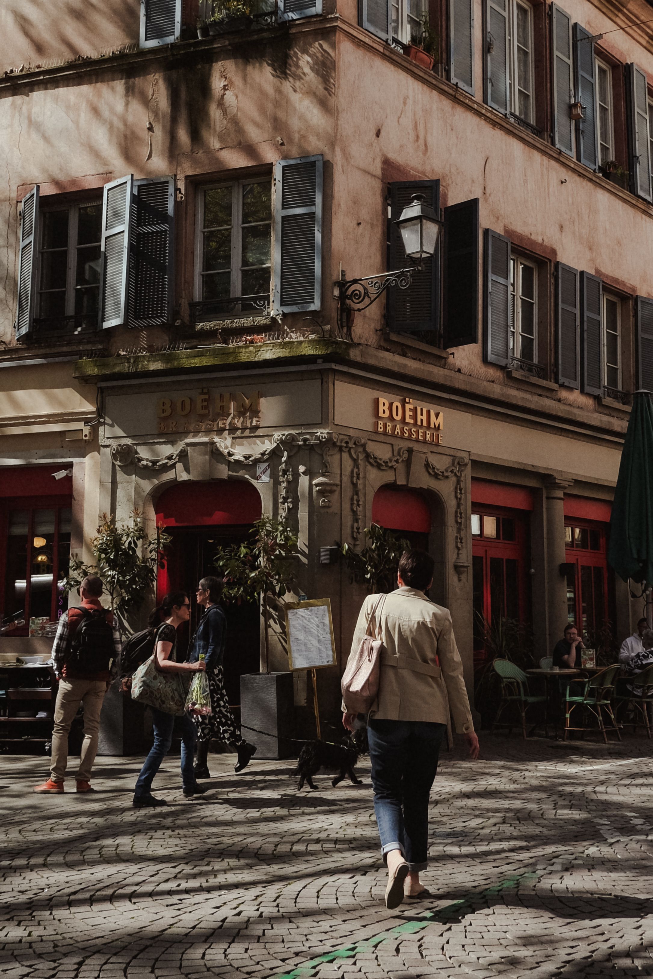 Charming French Street Scene with Café and Pedestrians · Free Stock Photo