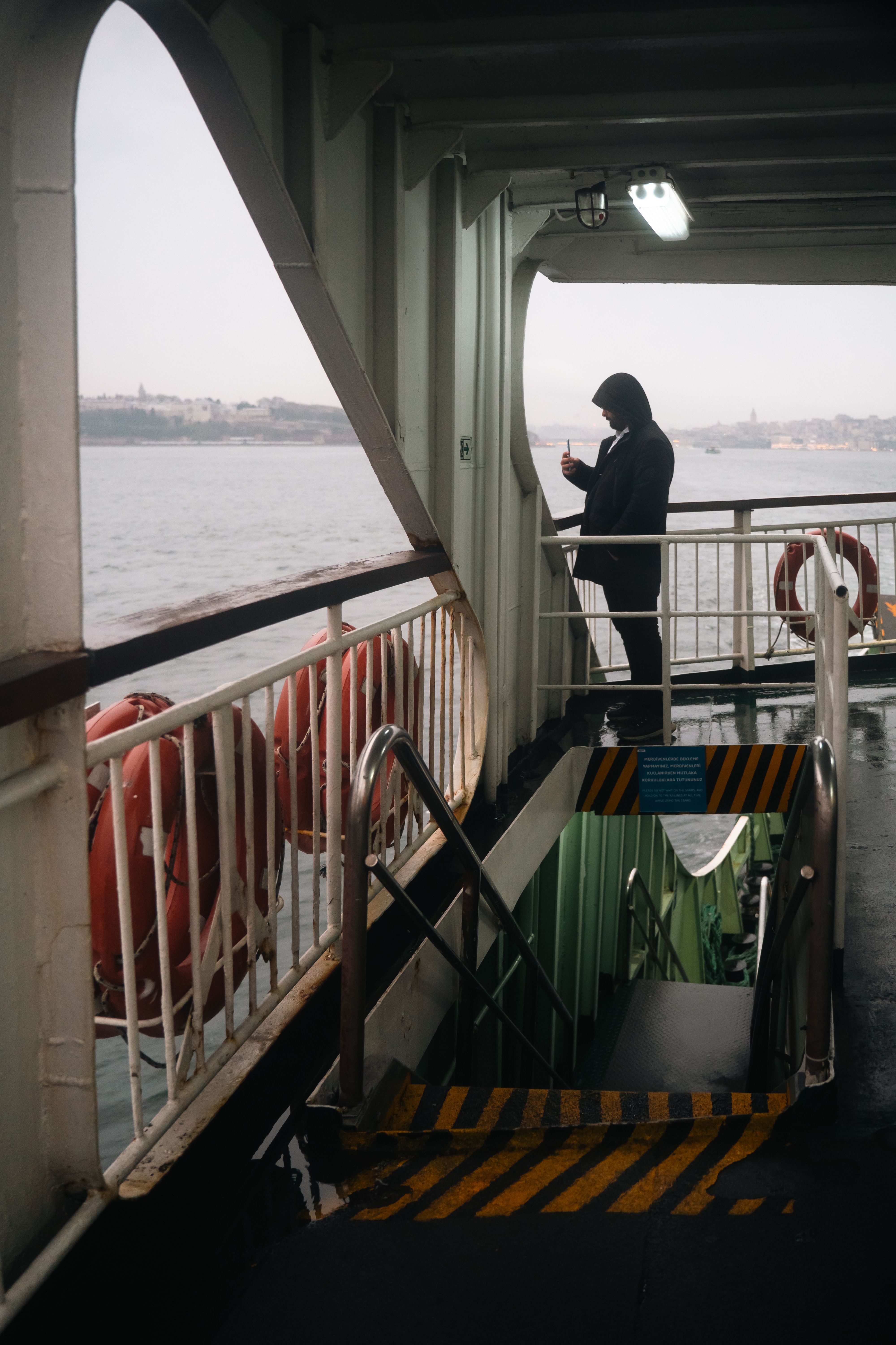 Person on ferry with scenic waterfront view · Free Stock Photo