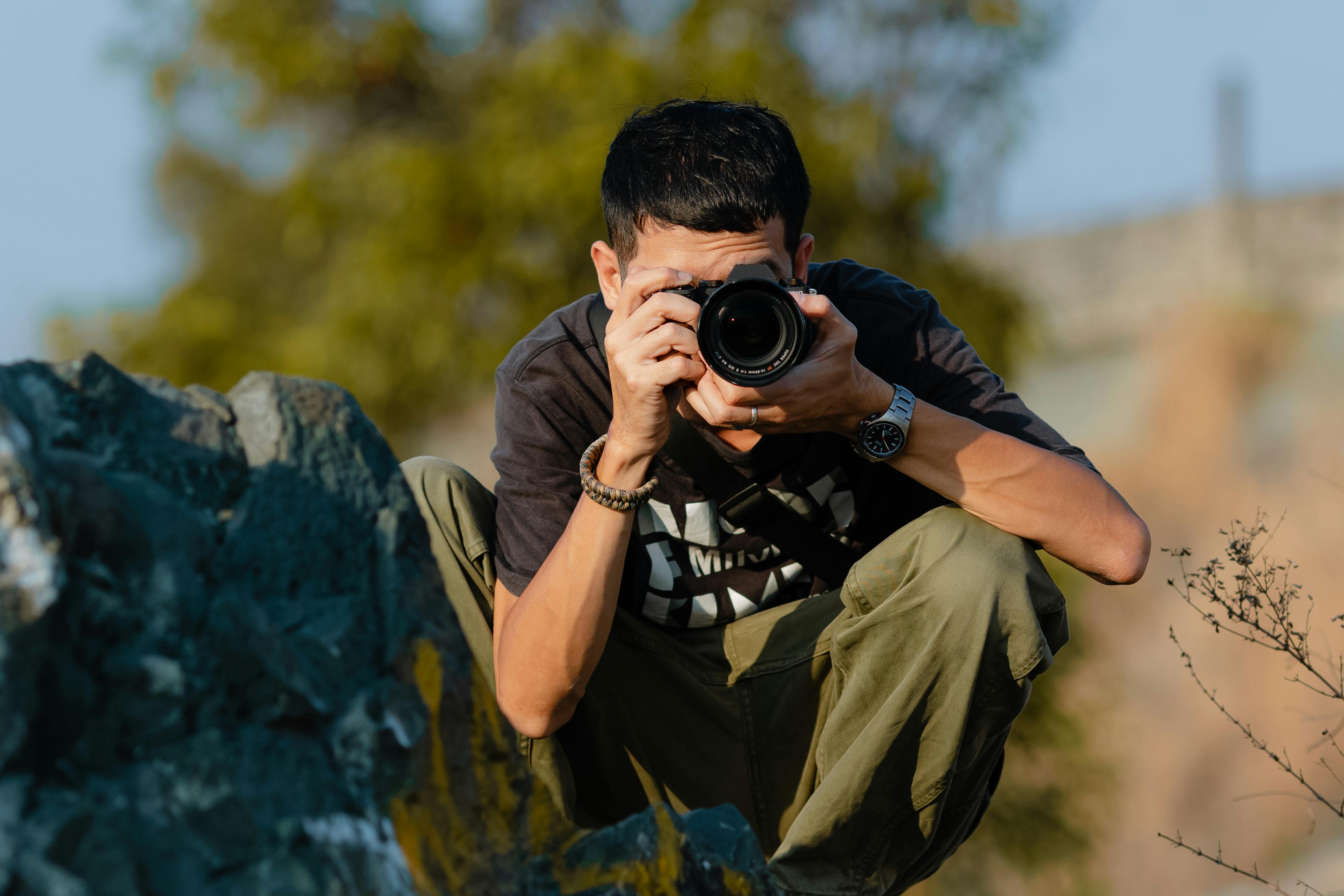 Photographer Crouching Outdoors in Vietnam · Free Stock Photo