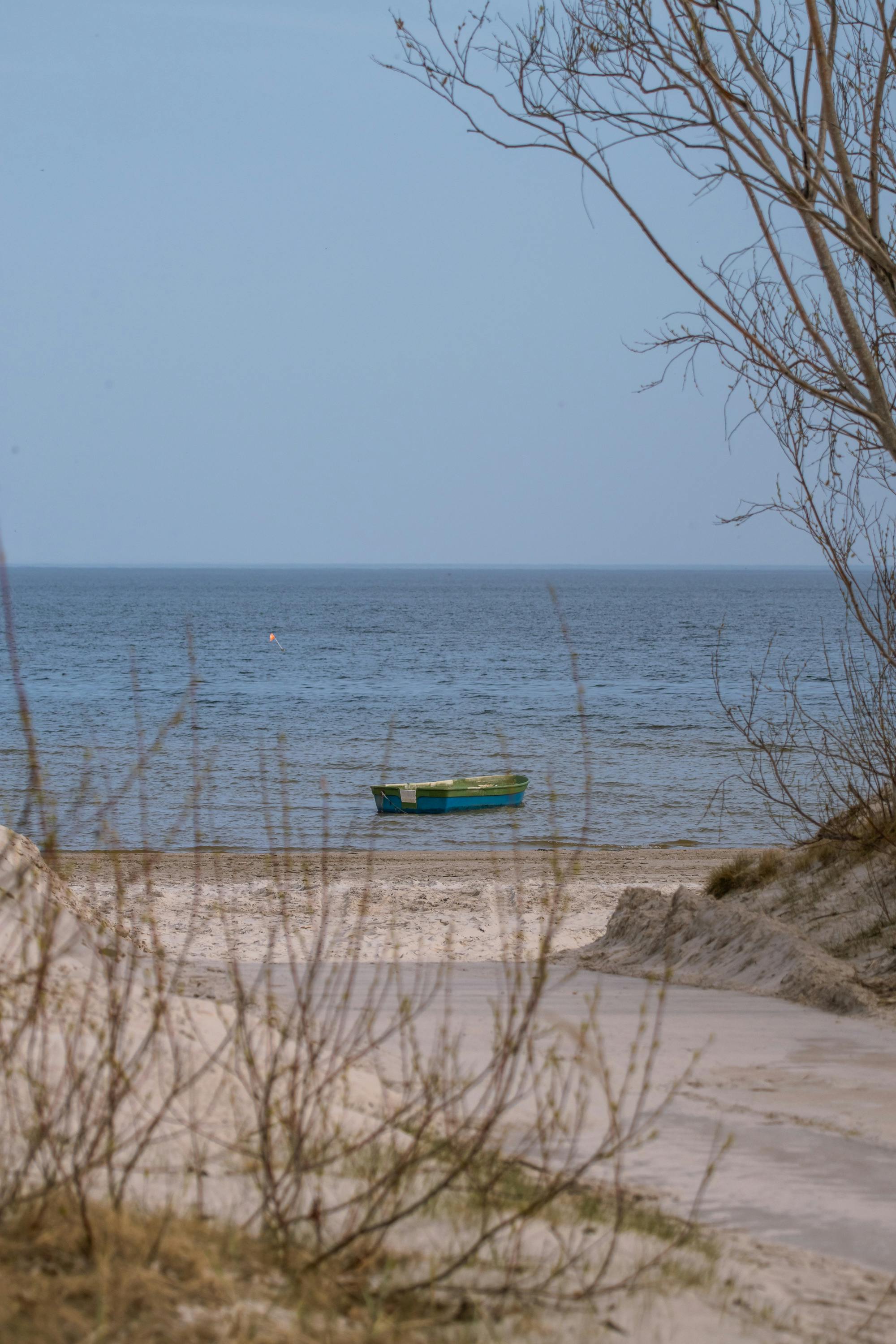 Serene Beach Scene with Lone Boat at Ragaciems · Free Stock Photo