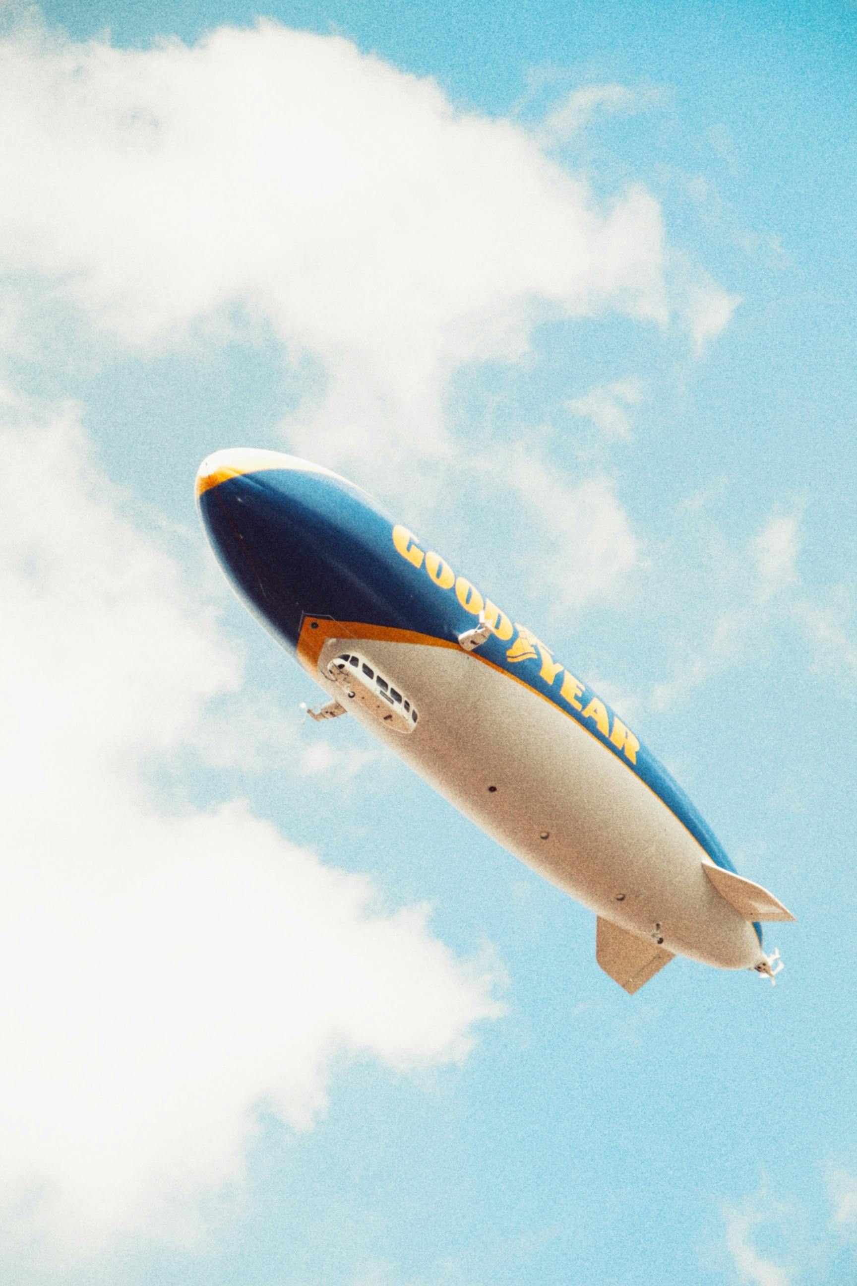 Goodyear Blimp in Blue Sky with Clouds · Free Stock Photo