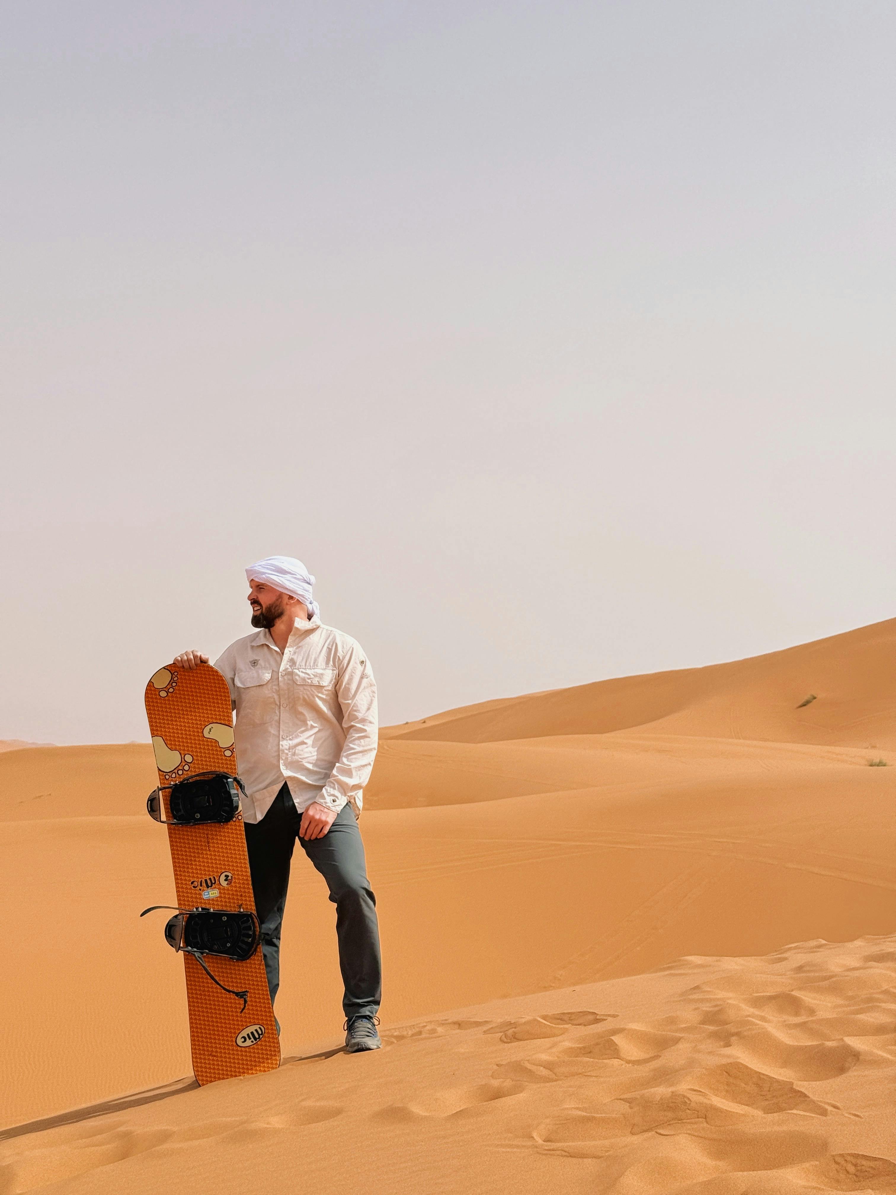 Man Sandboarding in Desert Landscape Adventure · Free Stock Photo