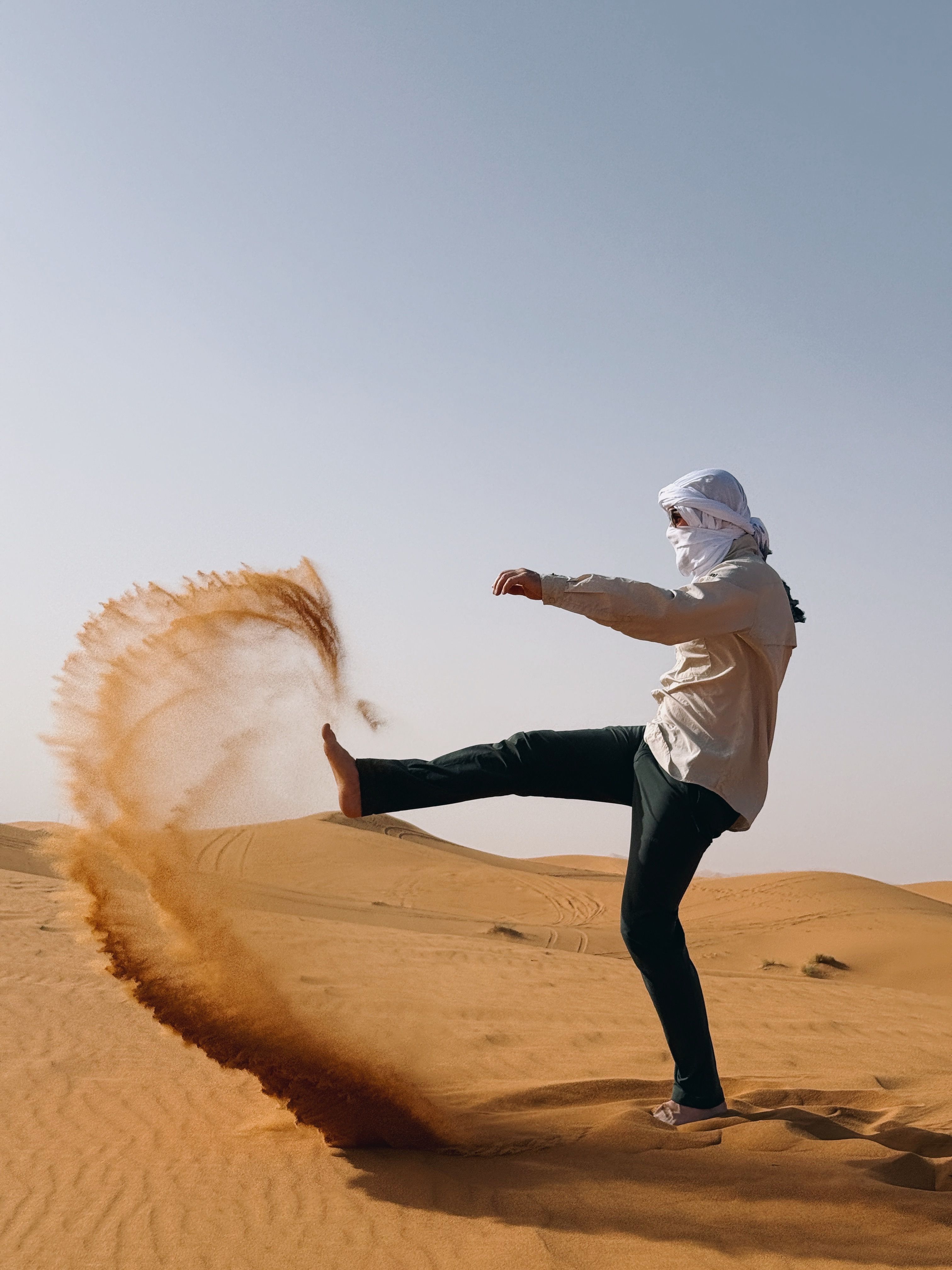 Man Kicking Sand in Desert Landscape · Free Stock Photo