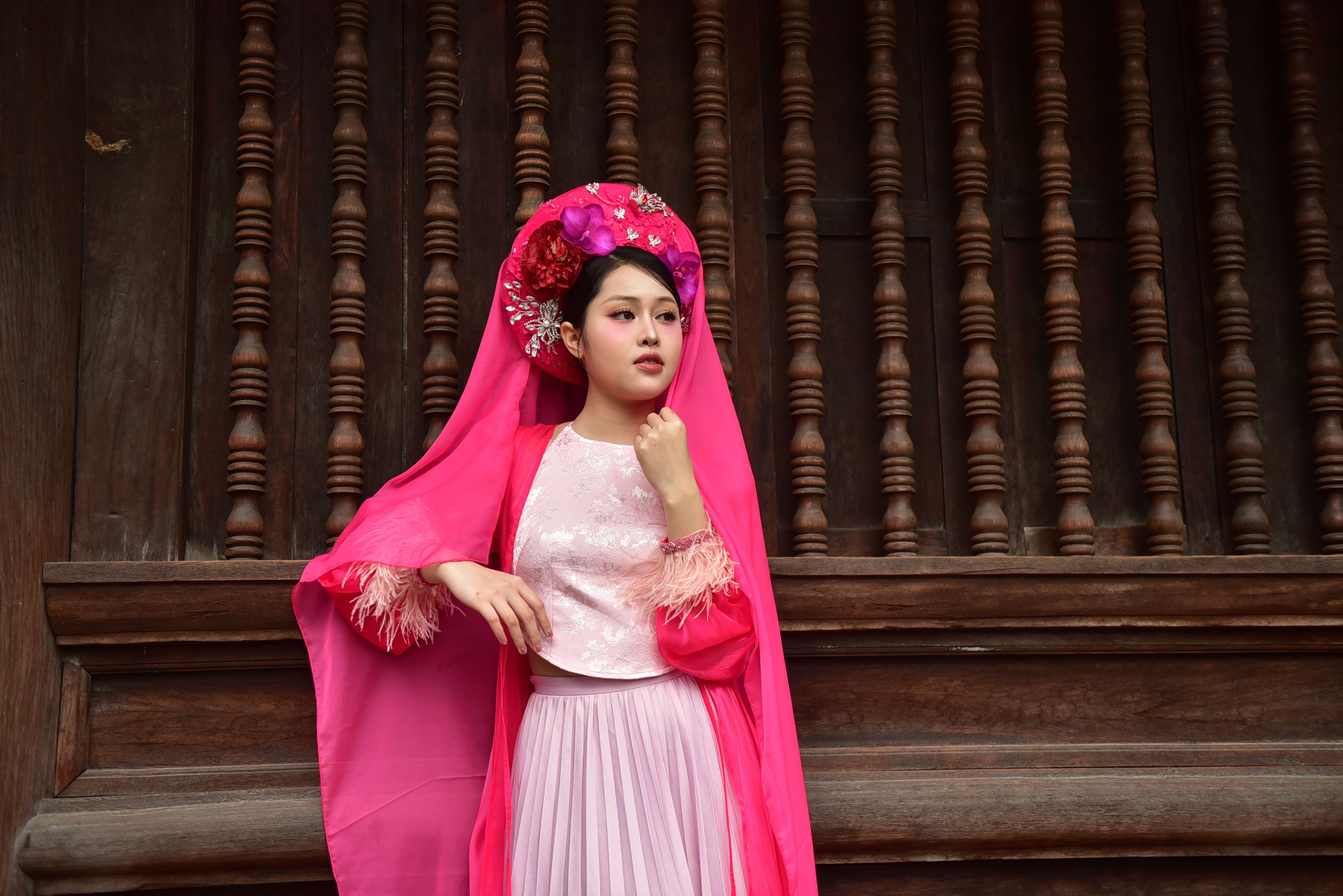 Woman in Traditional Pink Attire by Wooden Wall · Free Stock Photo