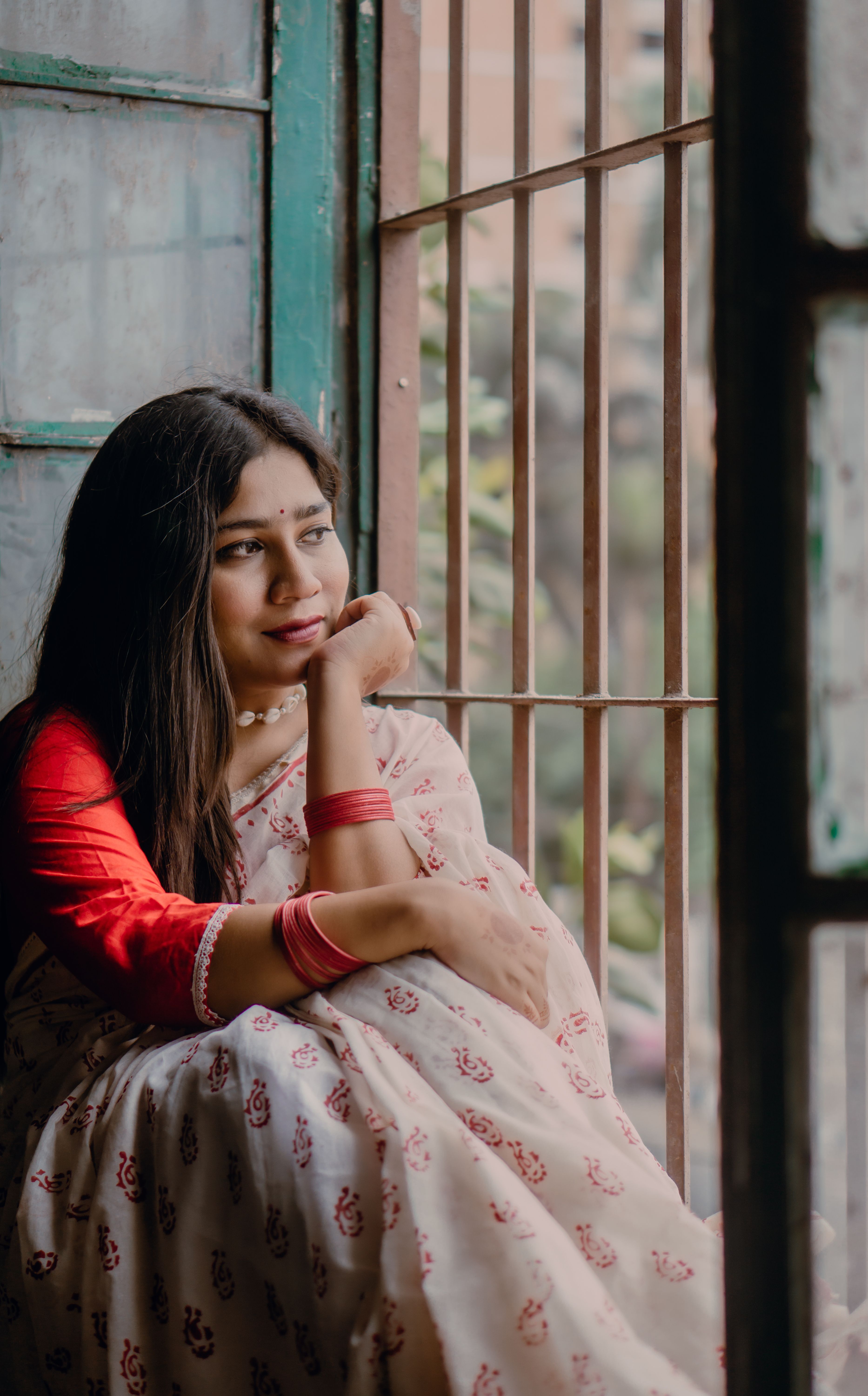Reflective Woman in Traditional Attire by Window · Free Stock Photo