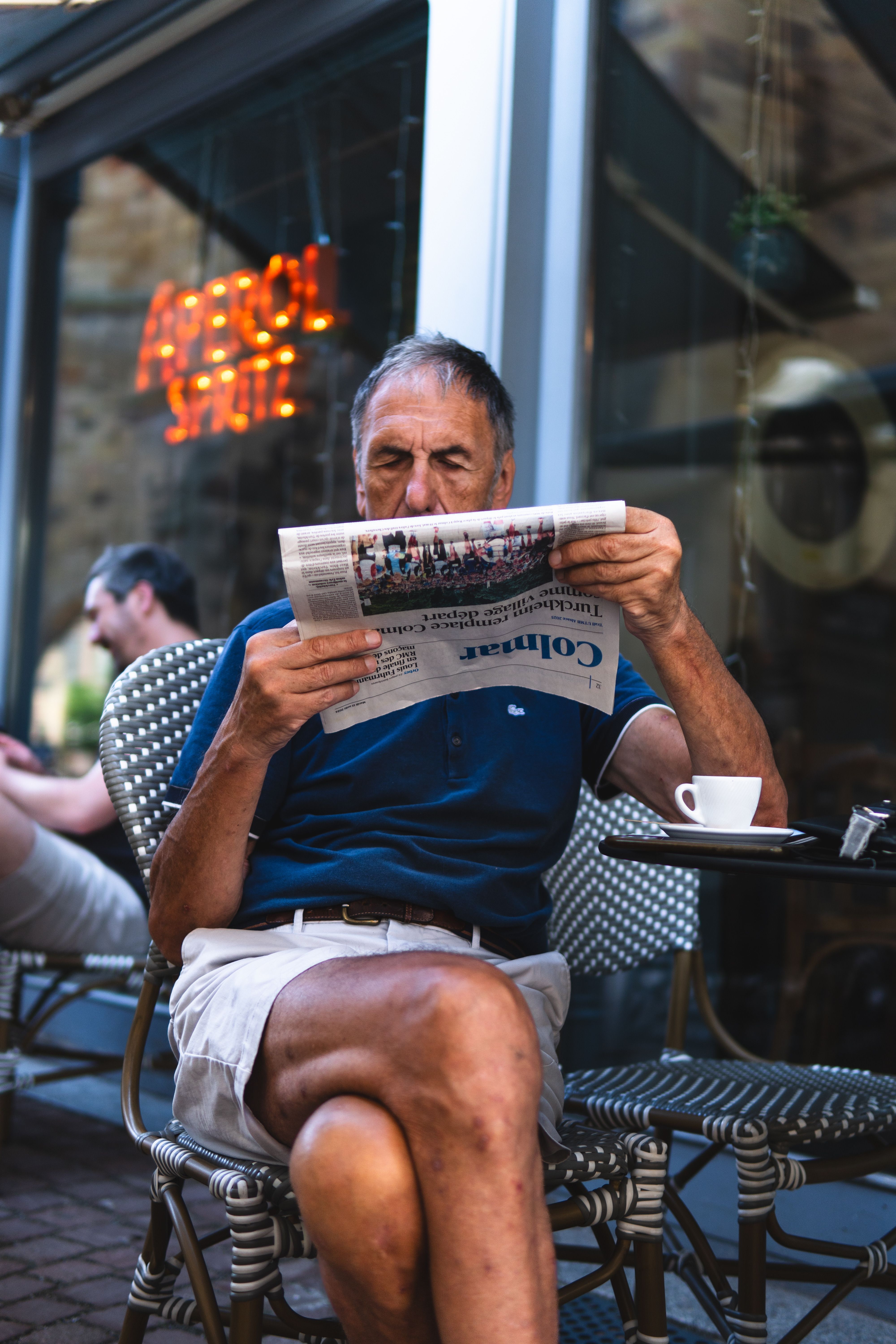 Man Reading Newspaper at Outdoor French Cafe · Free Stock Photo