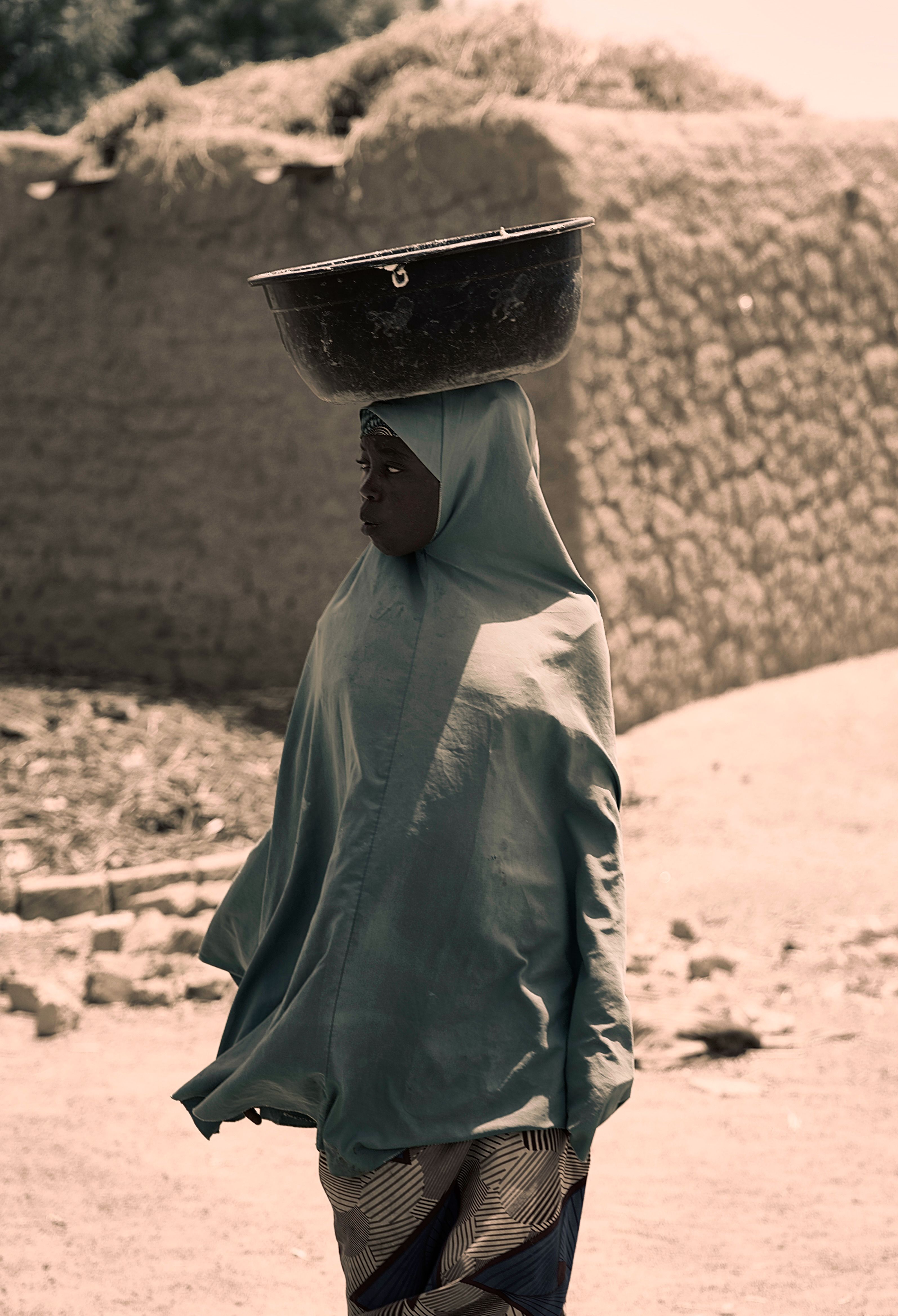 Traditional Nigerian Scene with Woman Carrying Basin · Free Stock Photo