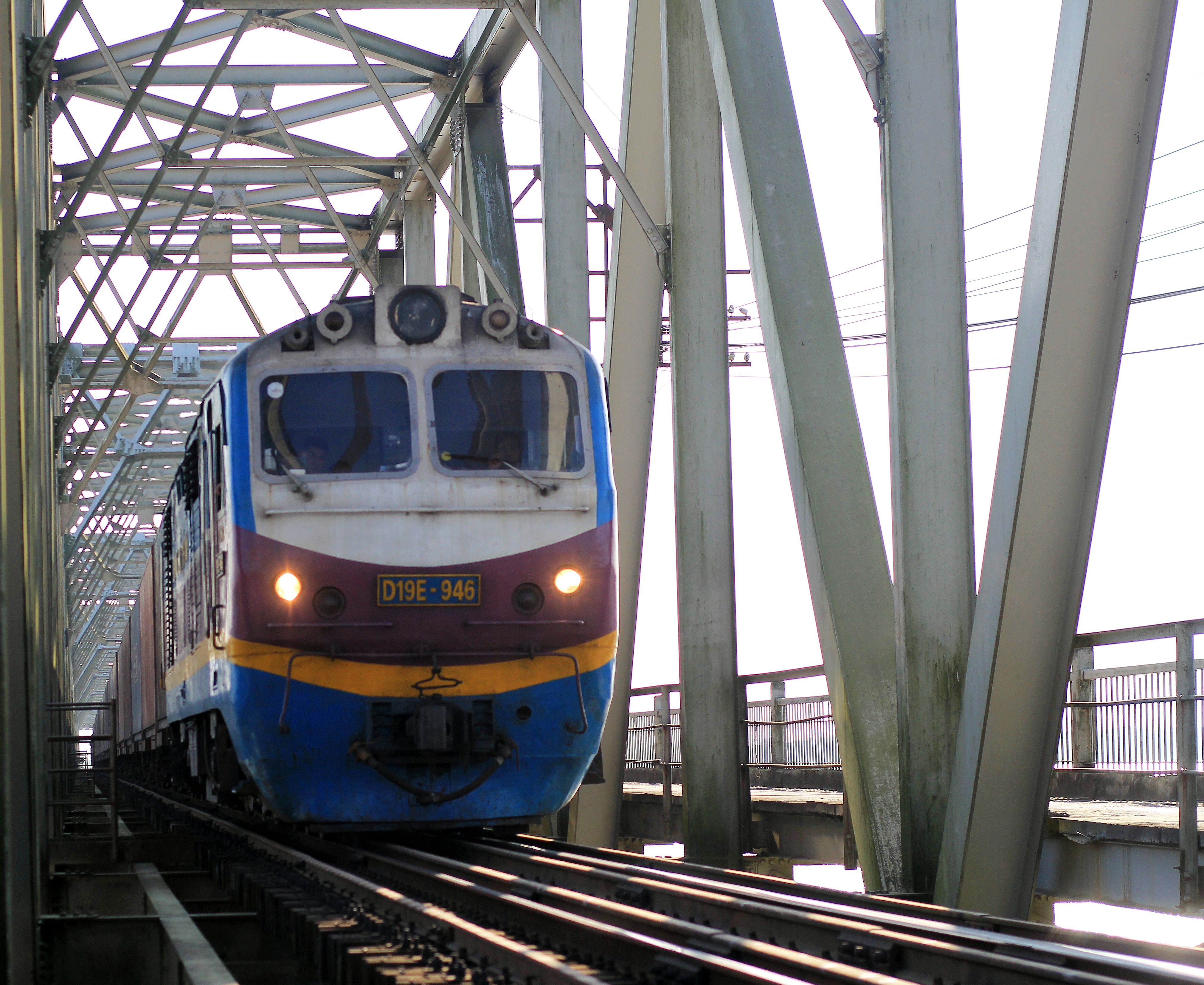 Train Crossing Overhead Steel Bridge with Blue Sky · Free Stock Photo