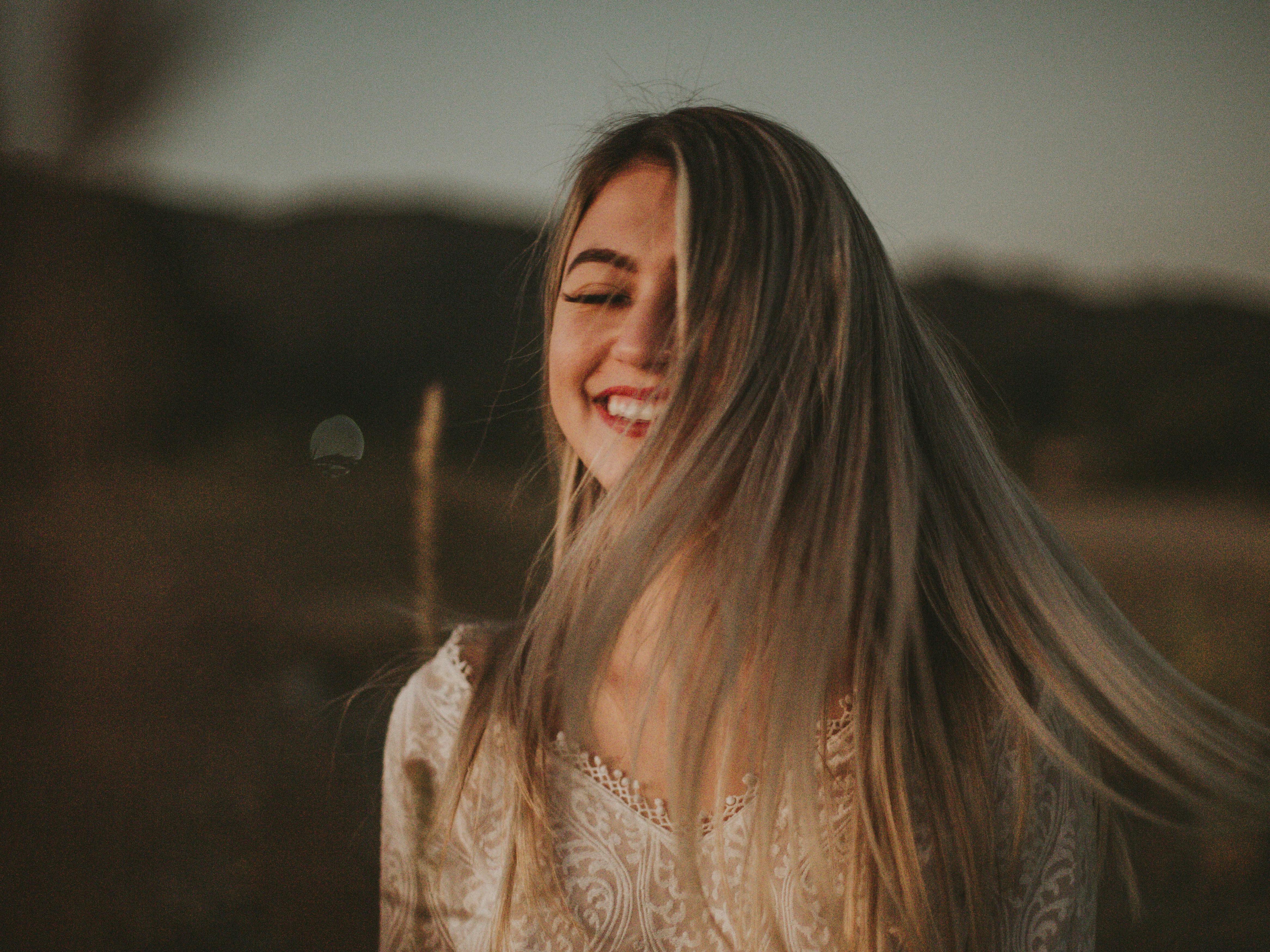 Joyful Woman Smiling in Nature at Sunset · Free Stock Photo