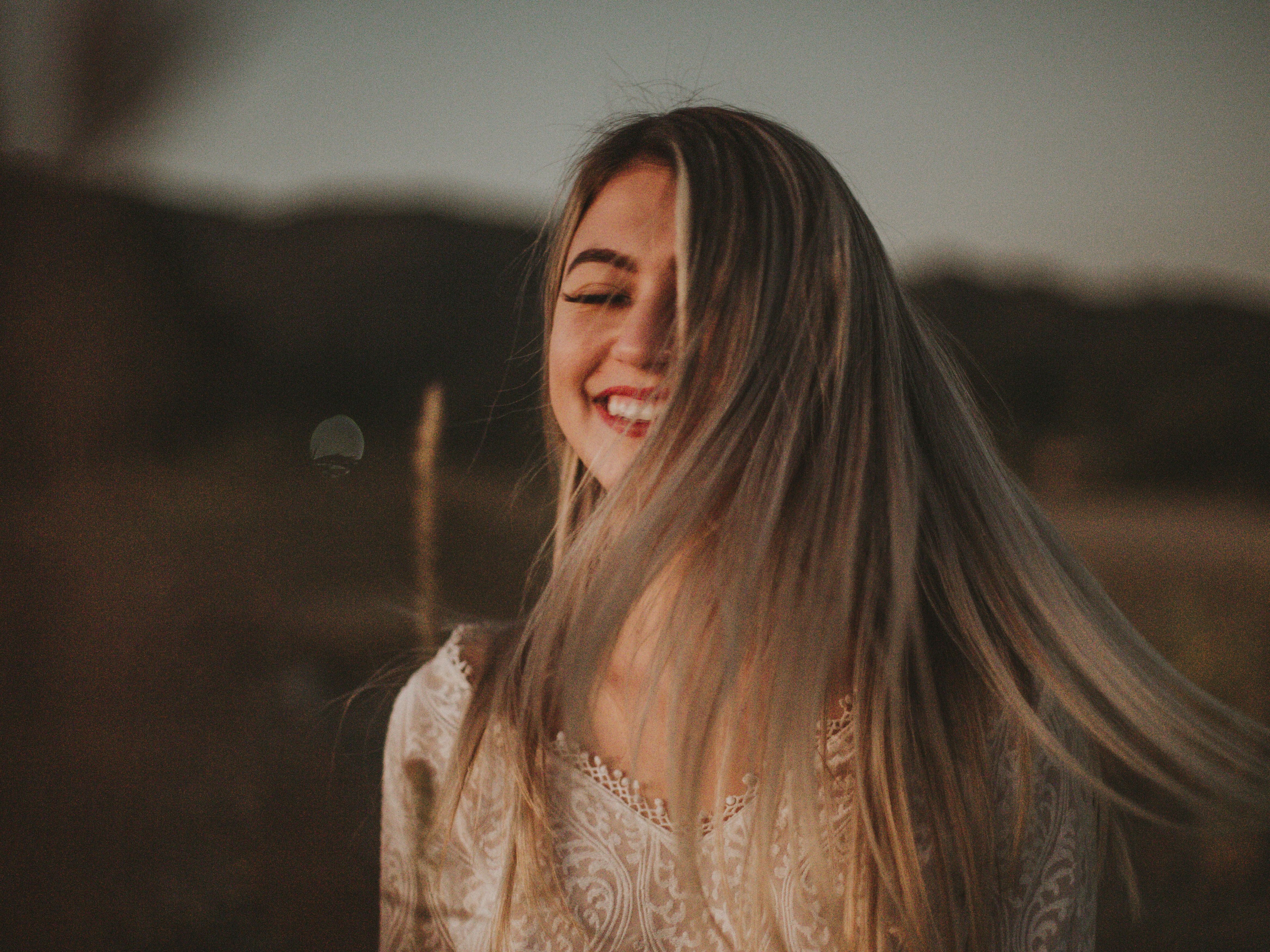 Joyful Woman Smiling in Nature at Sunset · Free Stock Photo