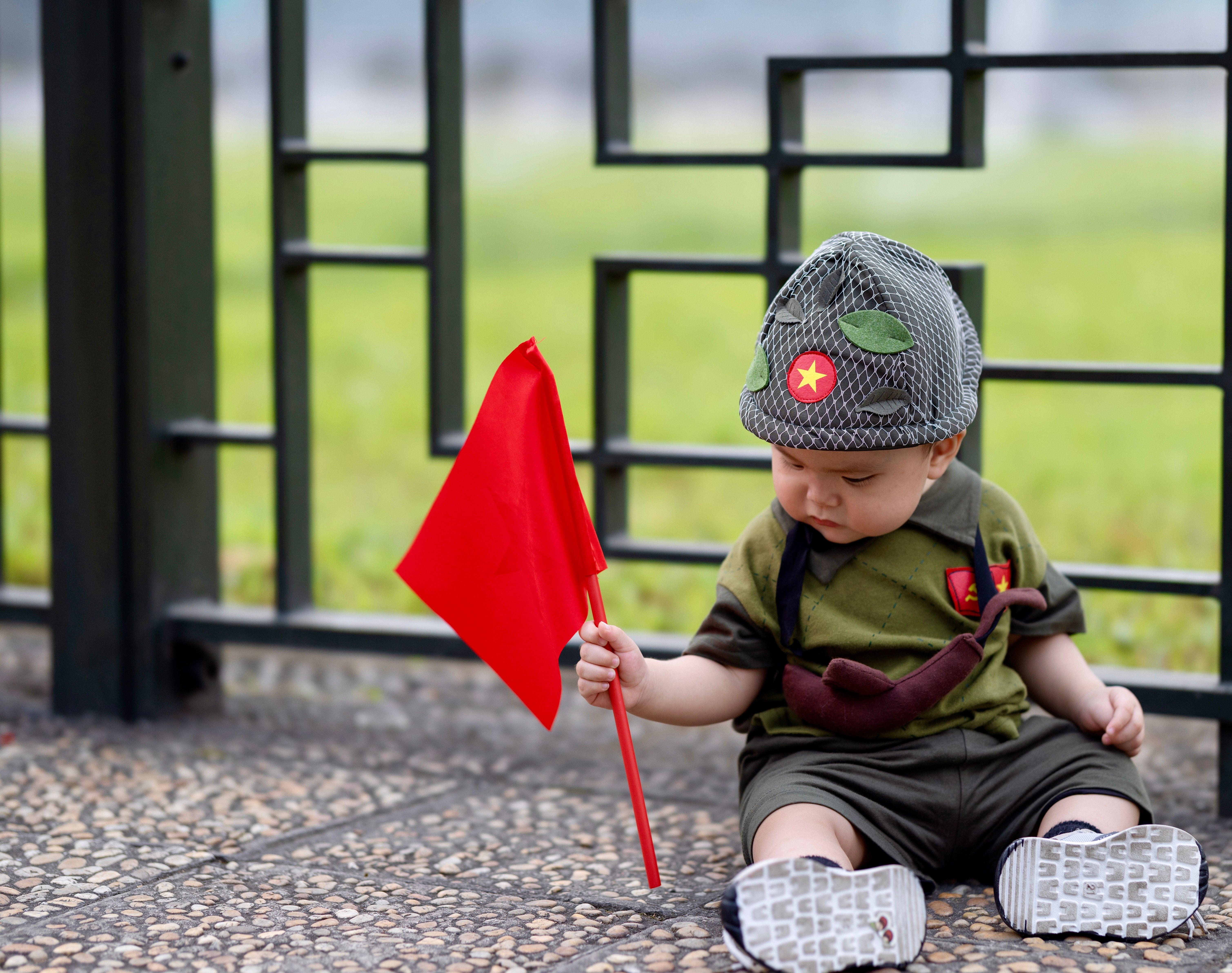 Adorable Baby Holding Red Flag Outdoors · Free Stock Photo