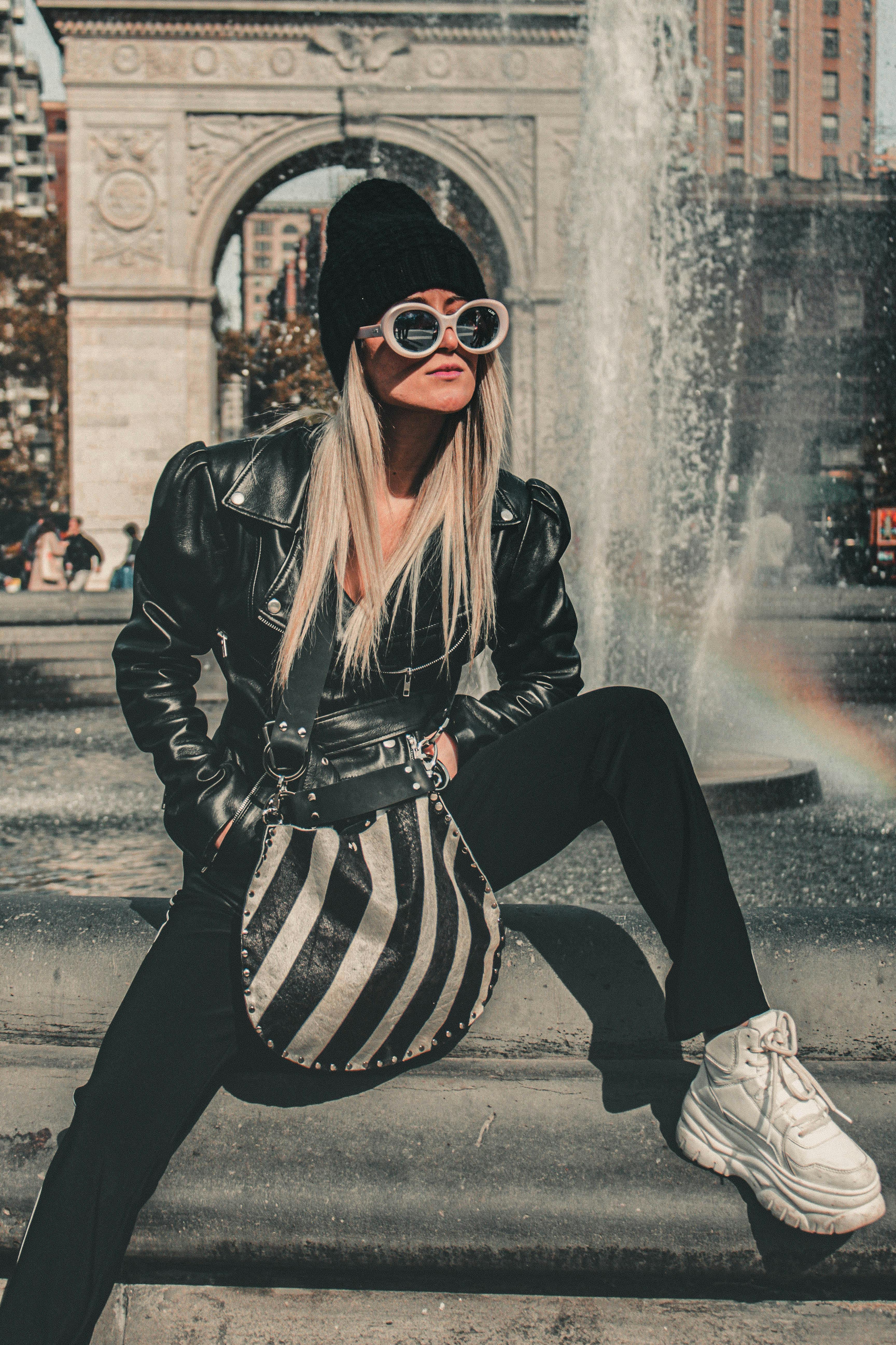 Stylish model with striped hand bag sitting near fountain · Free Stock ...