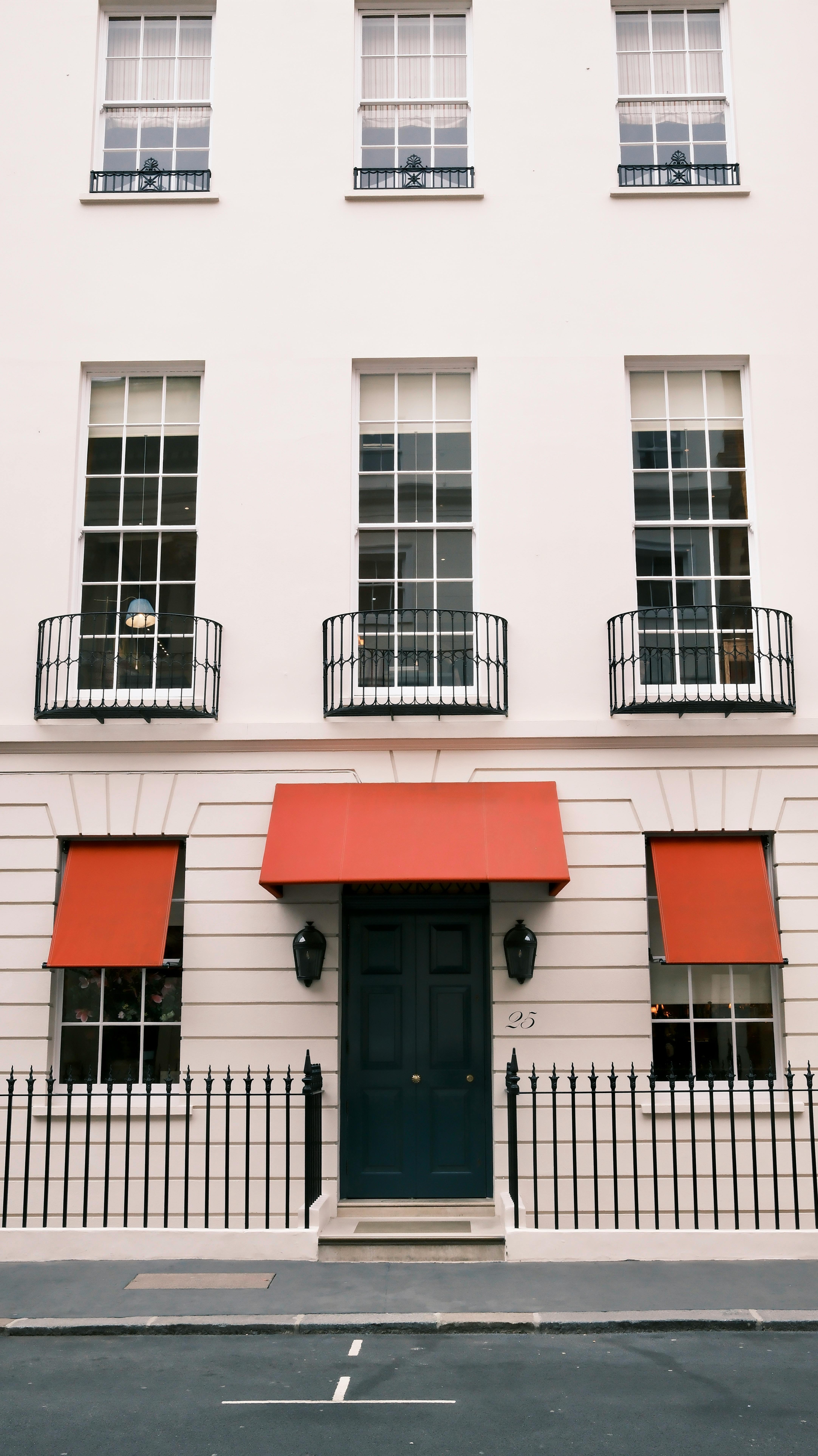Elegant Urban Building Facade with Red Awnings · Free Stock Photo