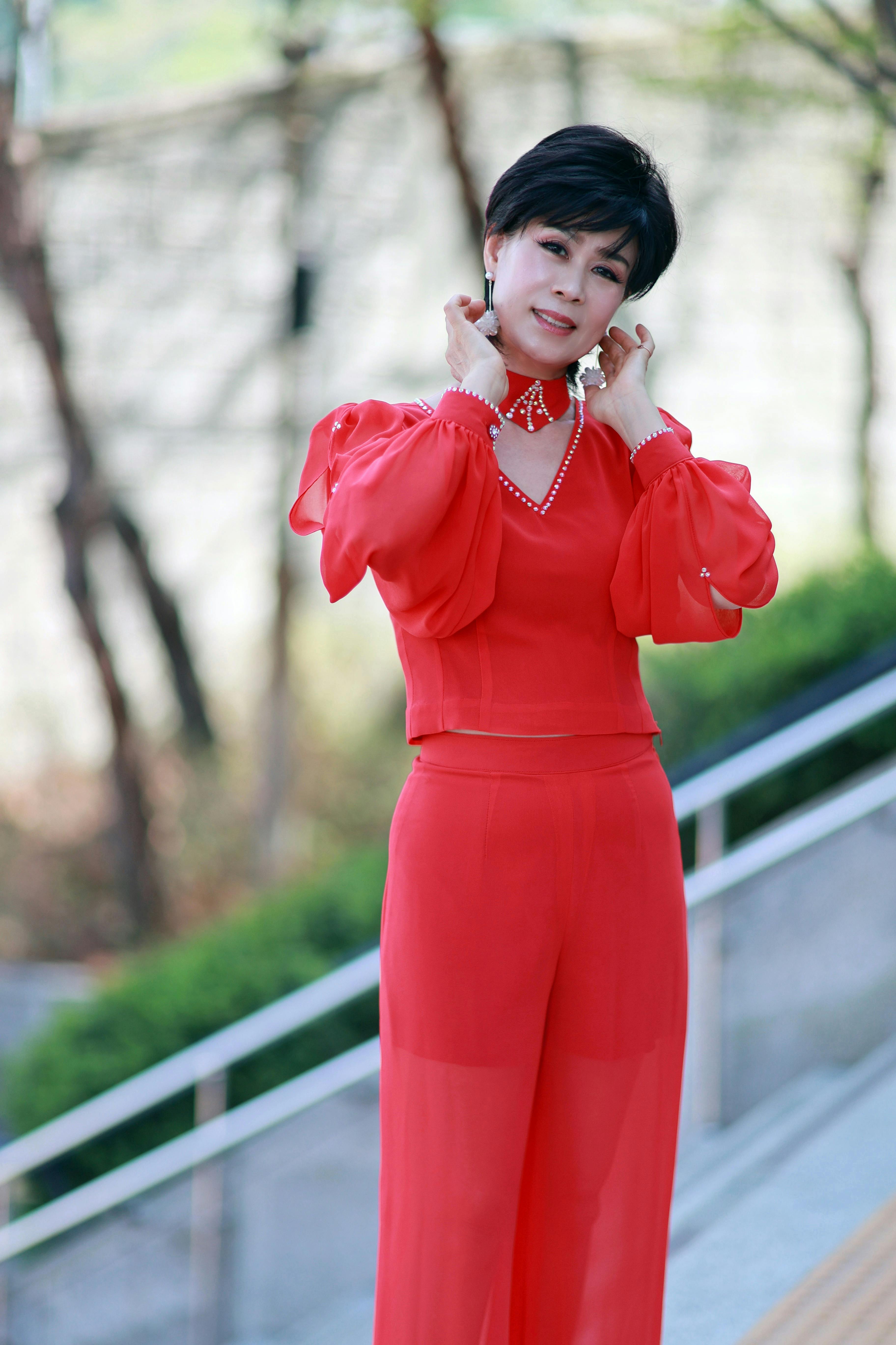 Elegant Woman in Red Chiffon Blouse Outdoors · Free Stock Photo