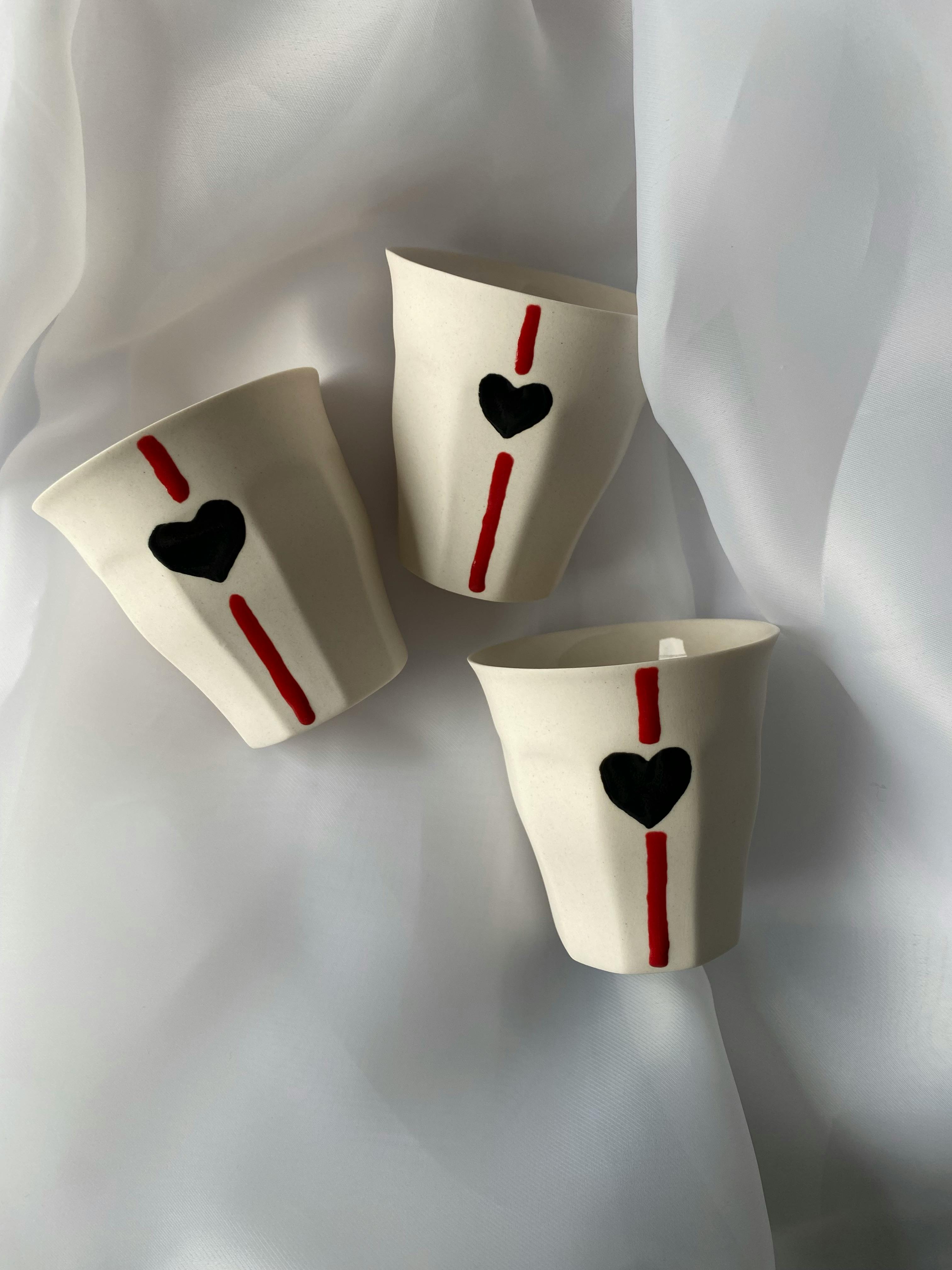 Artistic Ceramic Cups with Heart Design on Fabric · Free Stock Photo