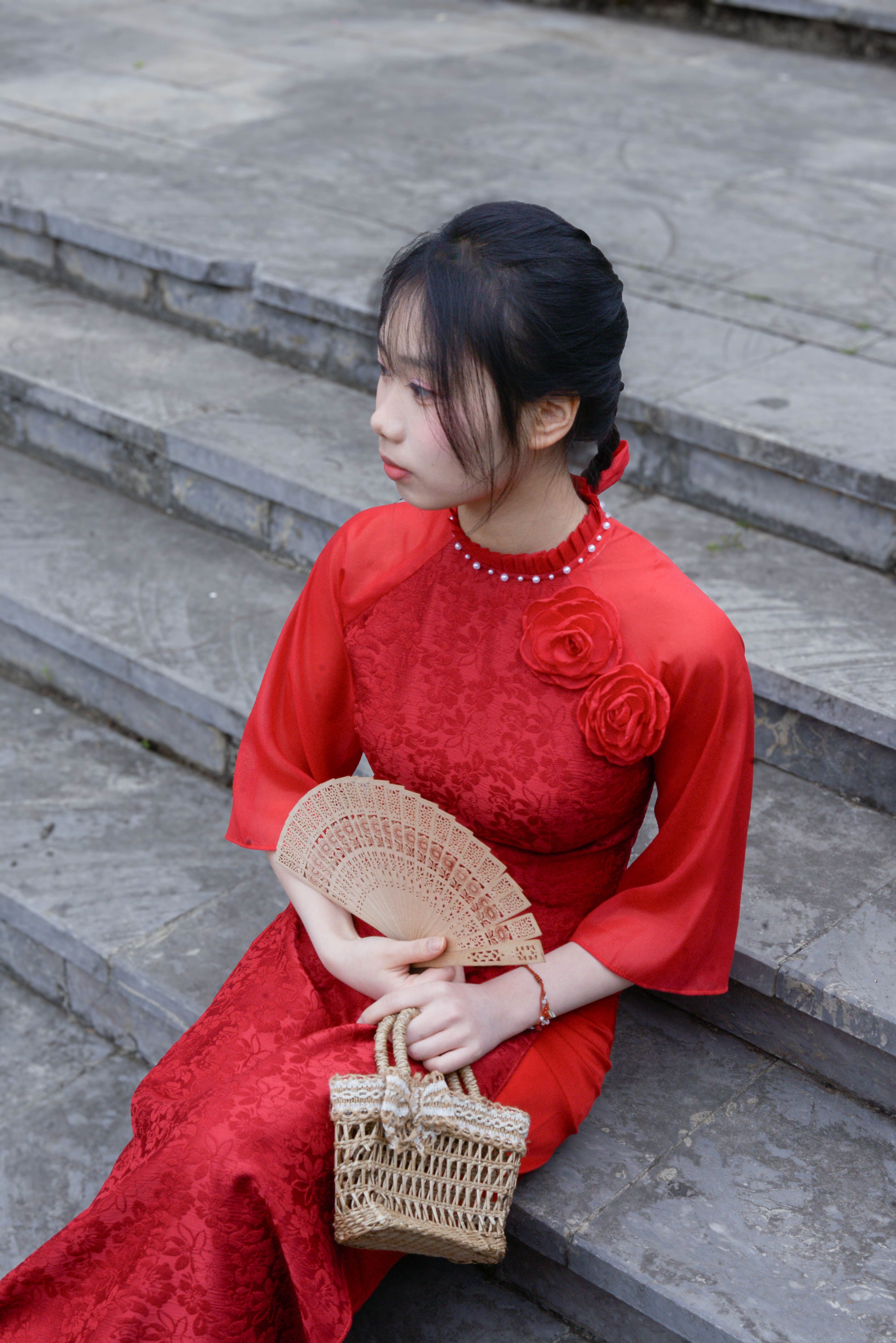 Woman in Red Dress Sitting on Steps with Fan · Free Stock Photo