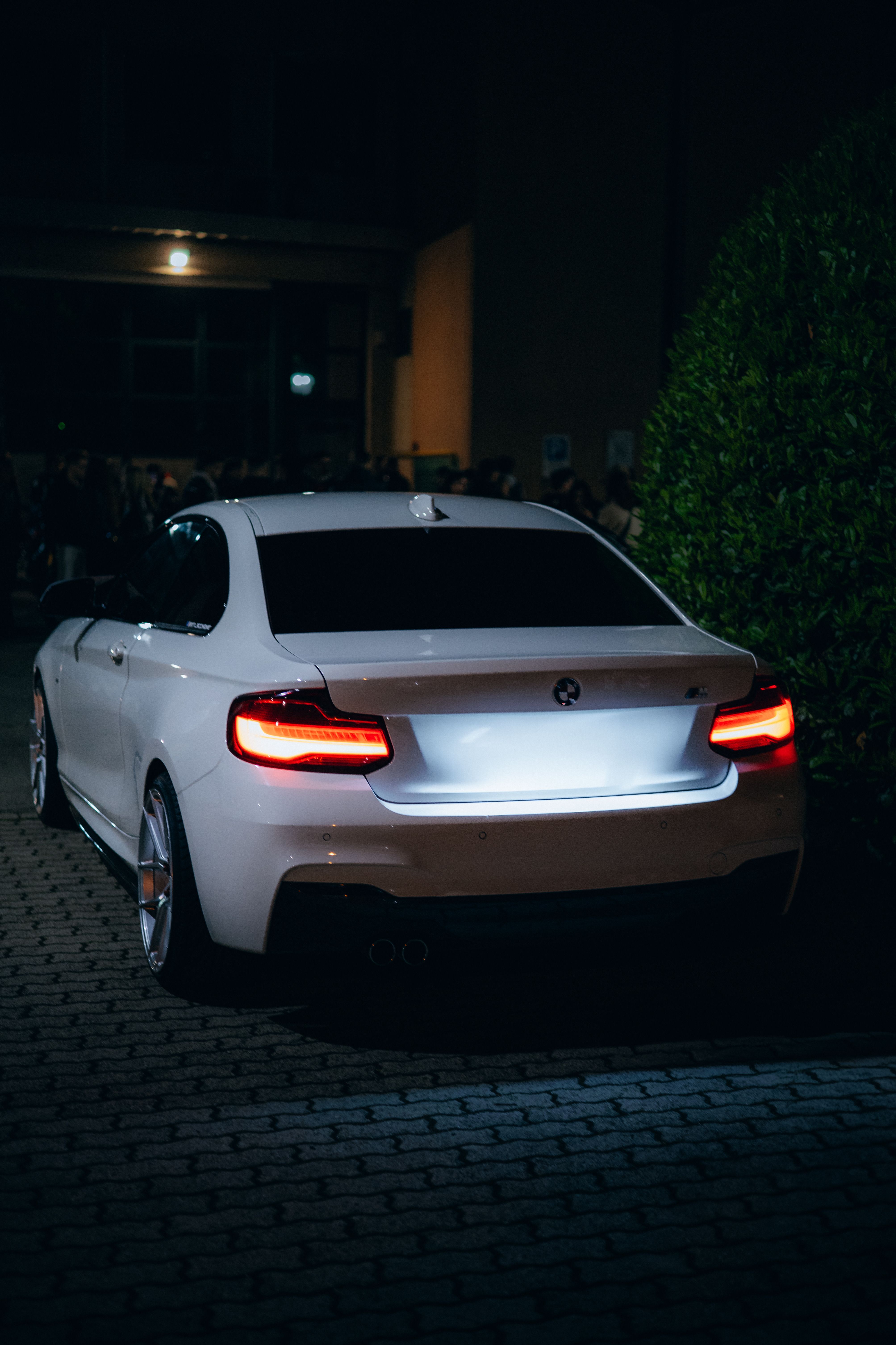 Sleek White Car at Night with Illuminated Taillights · Free Stock Photo